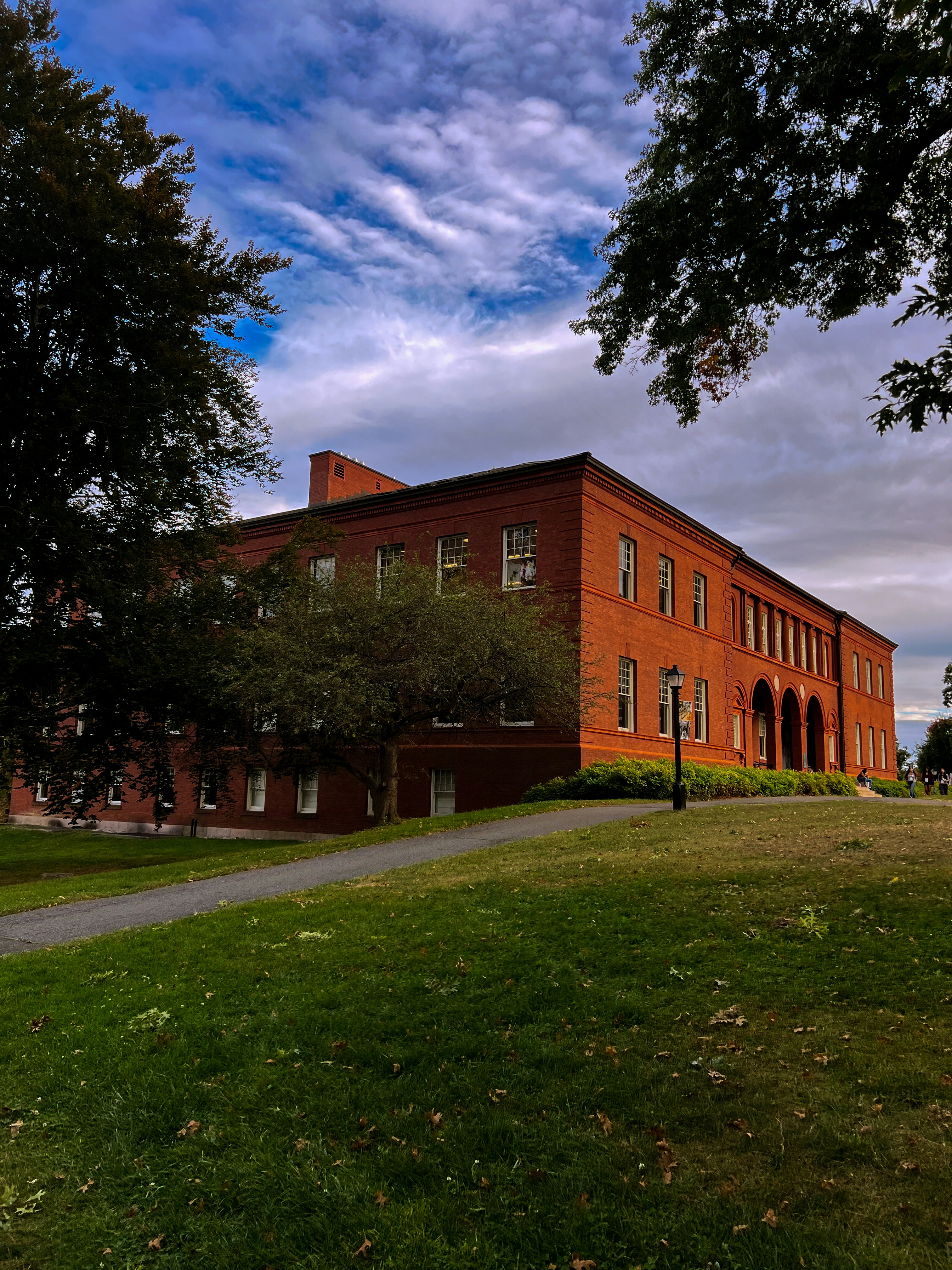 Fayerweather Hall at Amherst College | A red brick building sitting on top of a lush green field