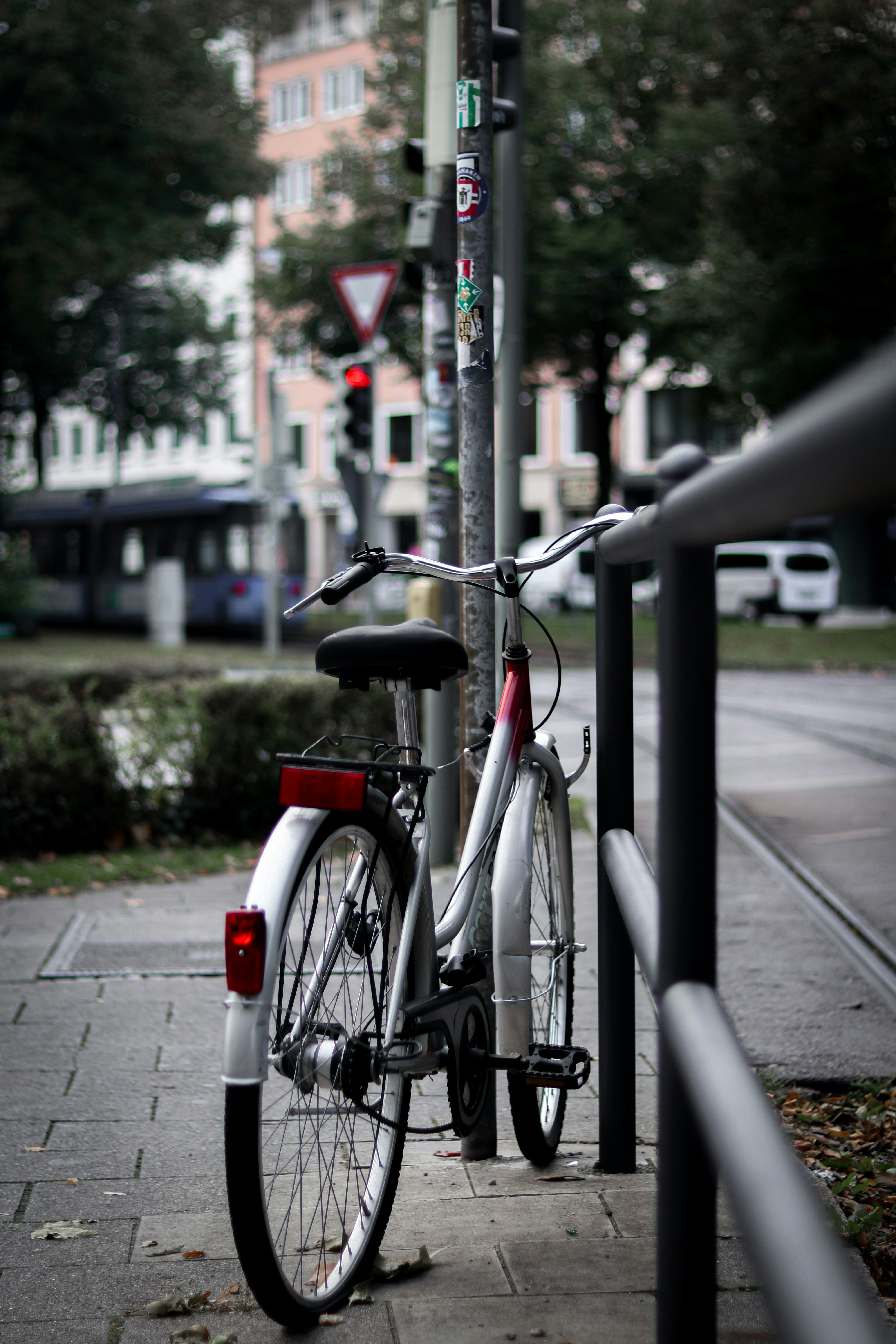 A bicycle is chained to a pole on a sidewalk photo – Free Bike Image on ...