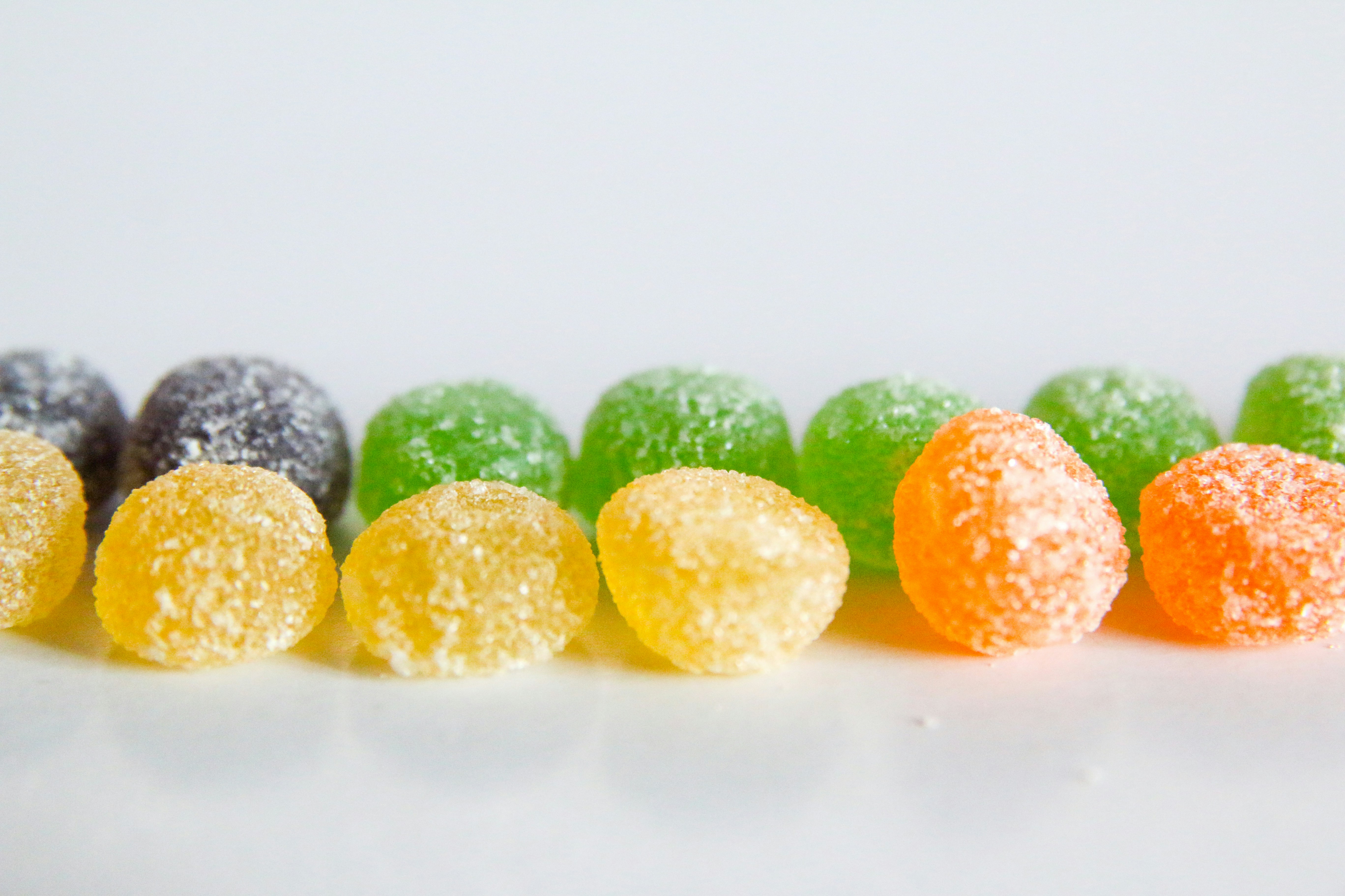 A row of different colored candies sitting next to each other photo ...