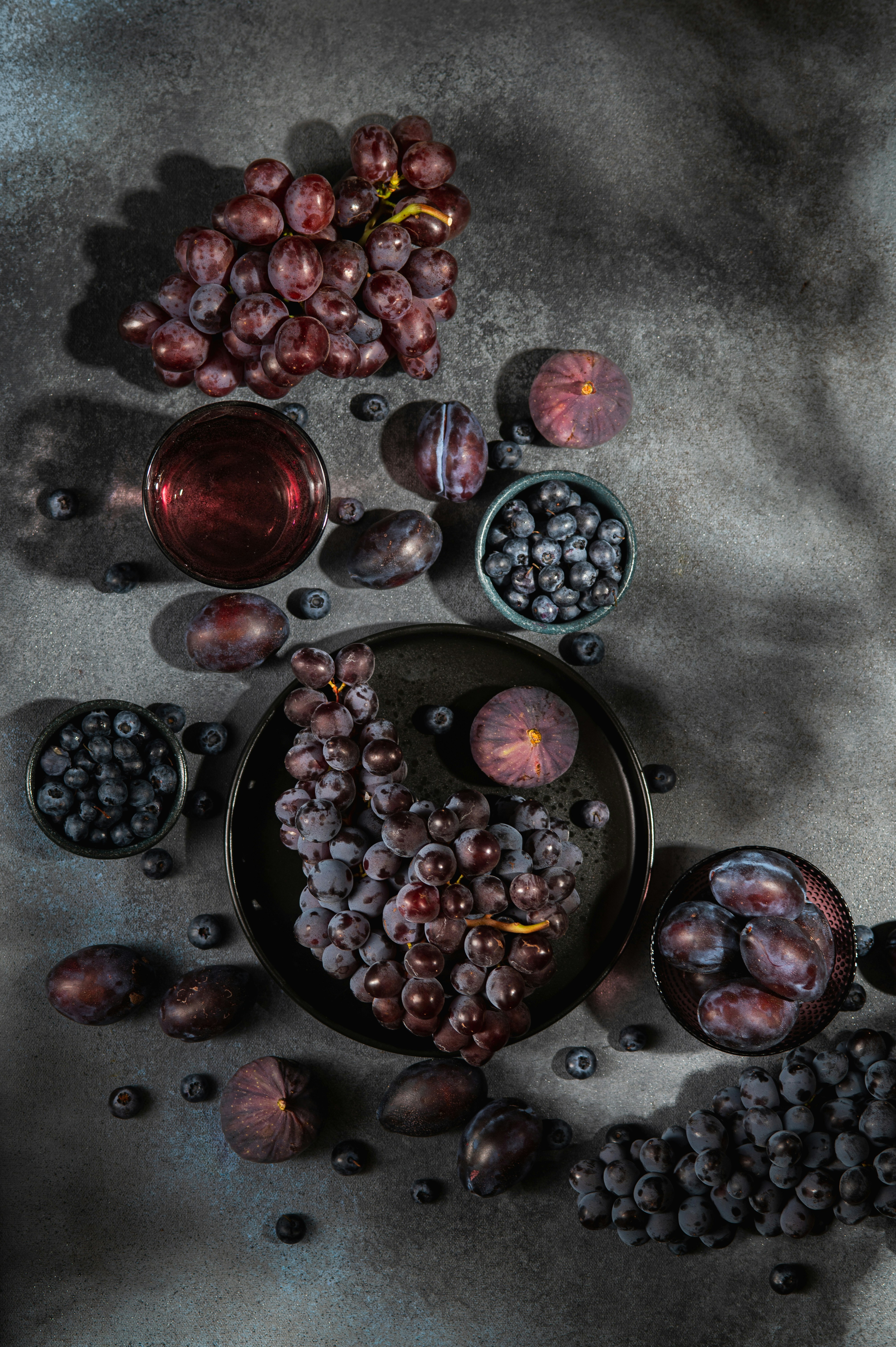 Velvet Bounty on Slate: A Moody Still-Life of Grapes, Plums, and Berries