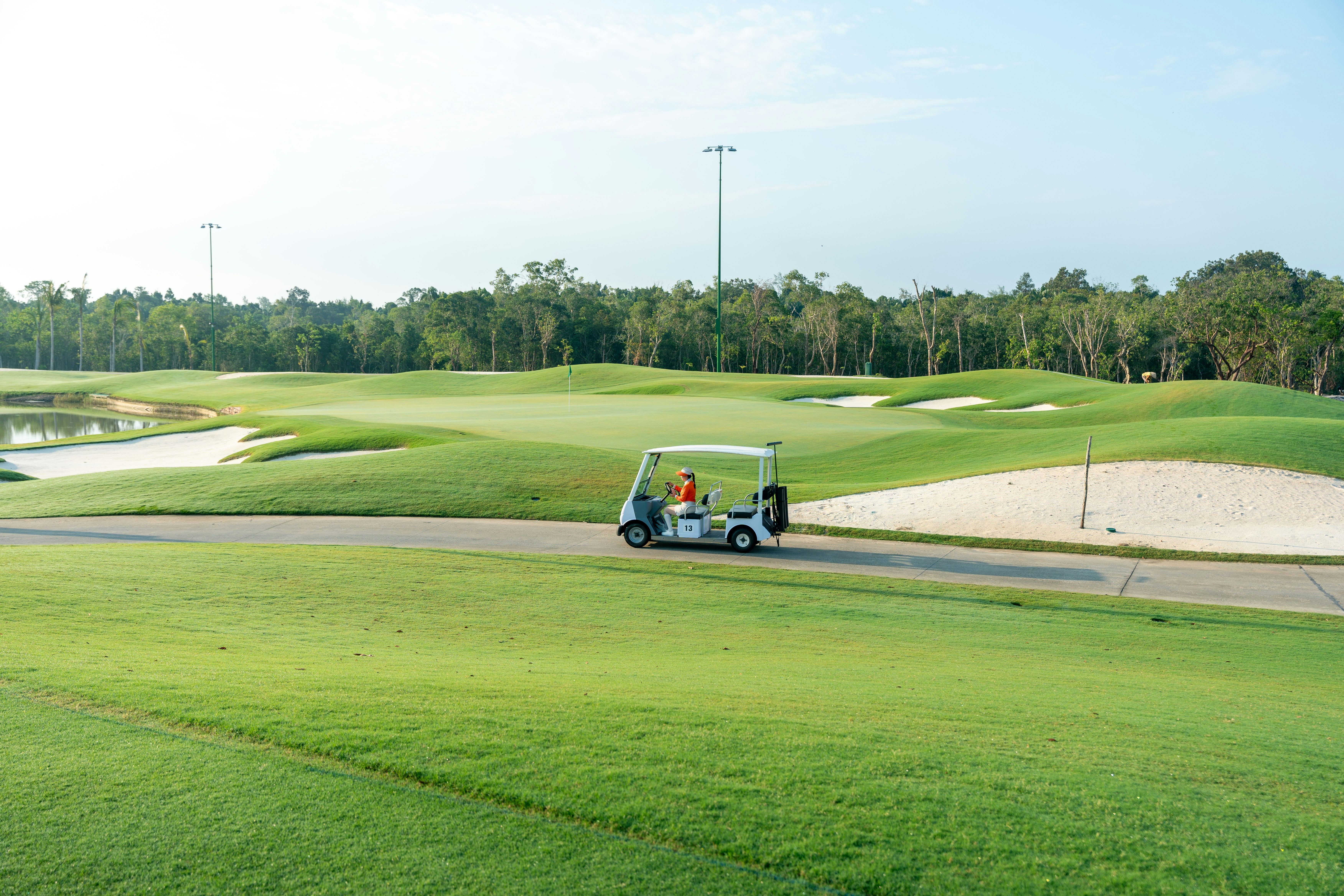 A golf cart driving down a golf course photo – Free Human Image on Unsplash