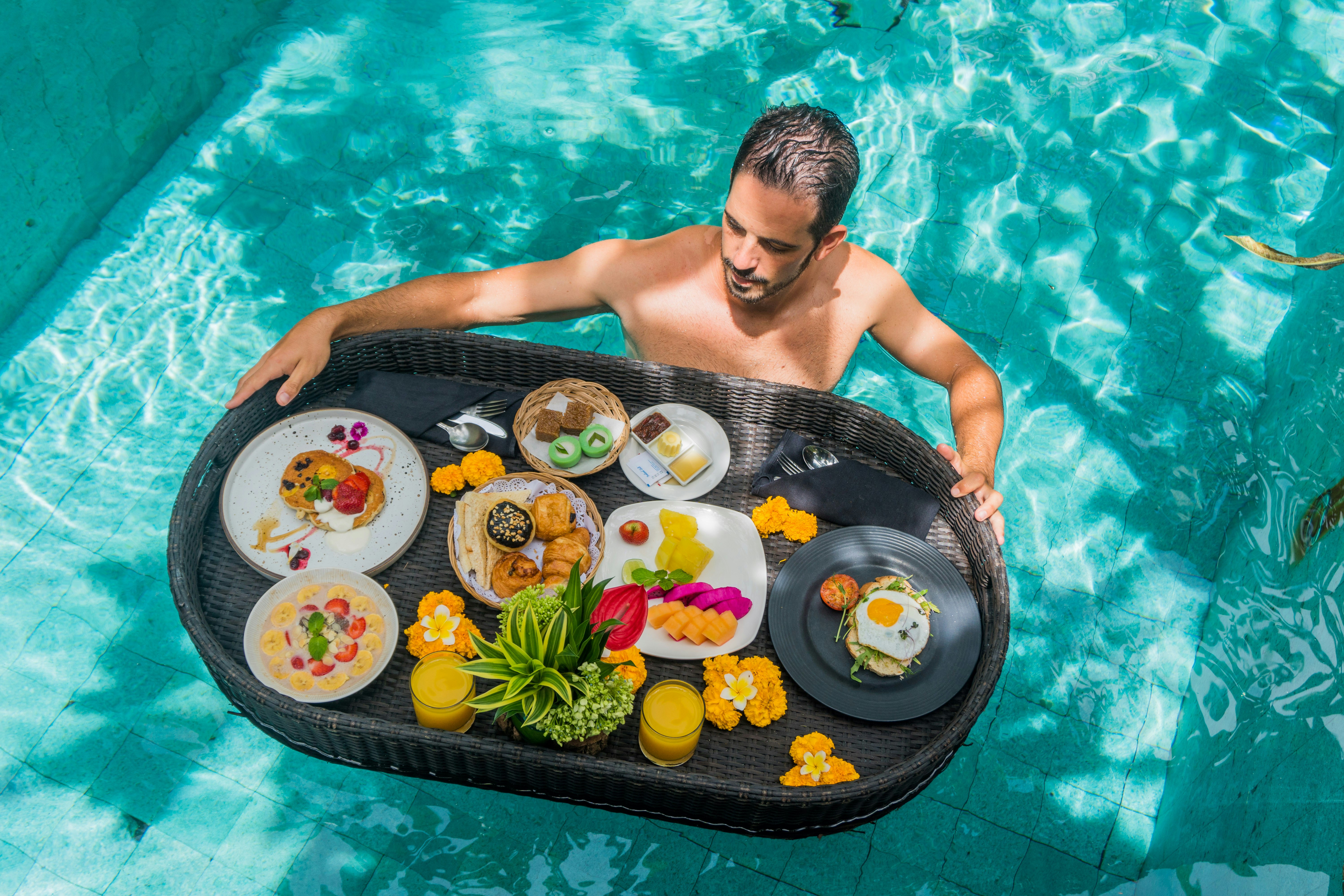 A man in a pool with a tray of food photo – Free Bali Image on Unsplash