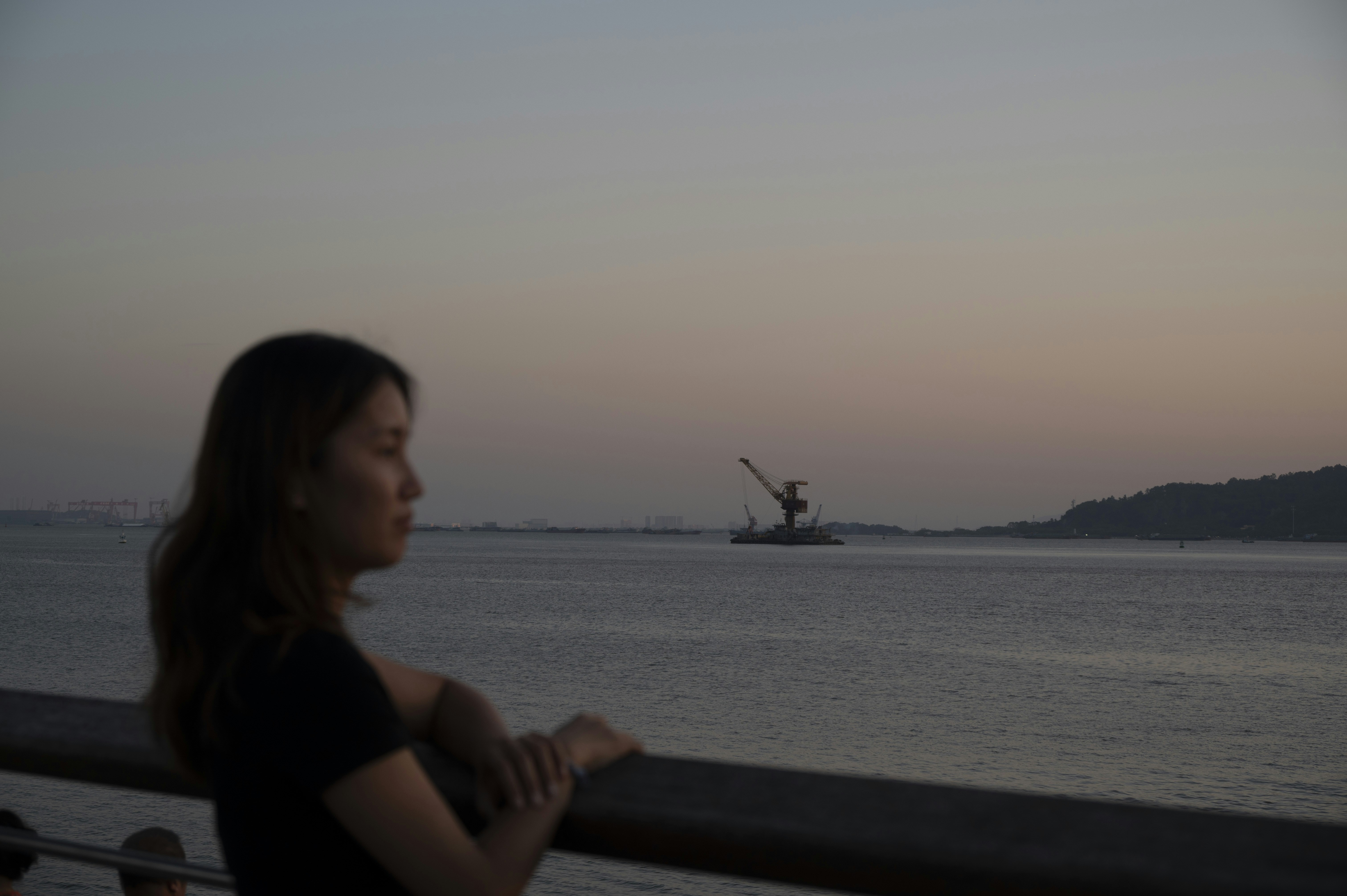 Dusk Riverfront: Quiet Contemplation by the Rail