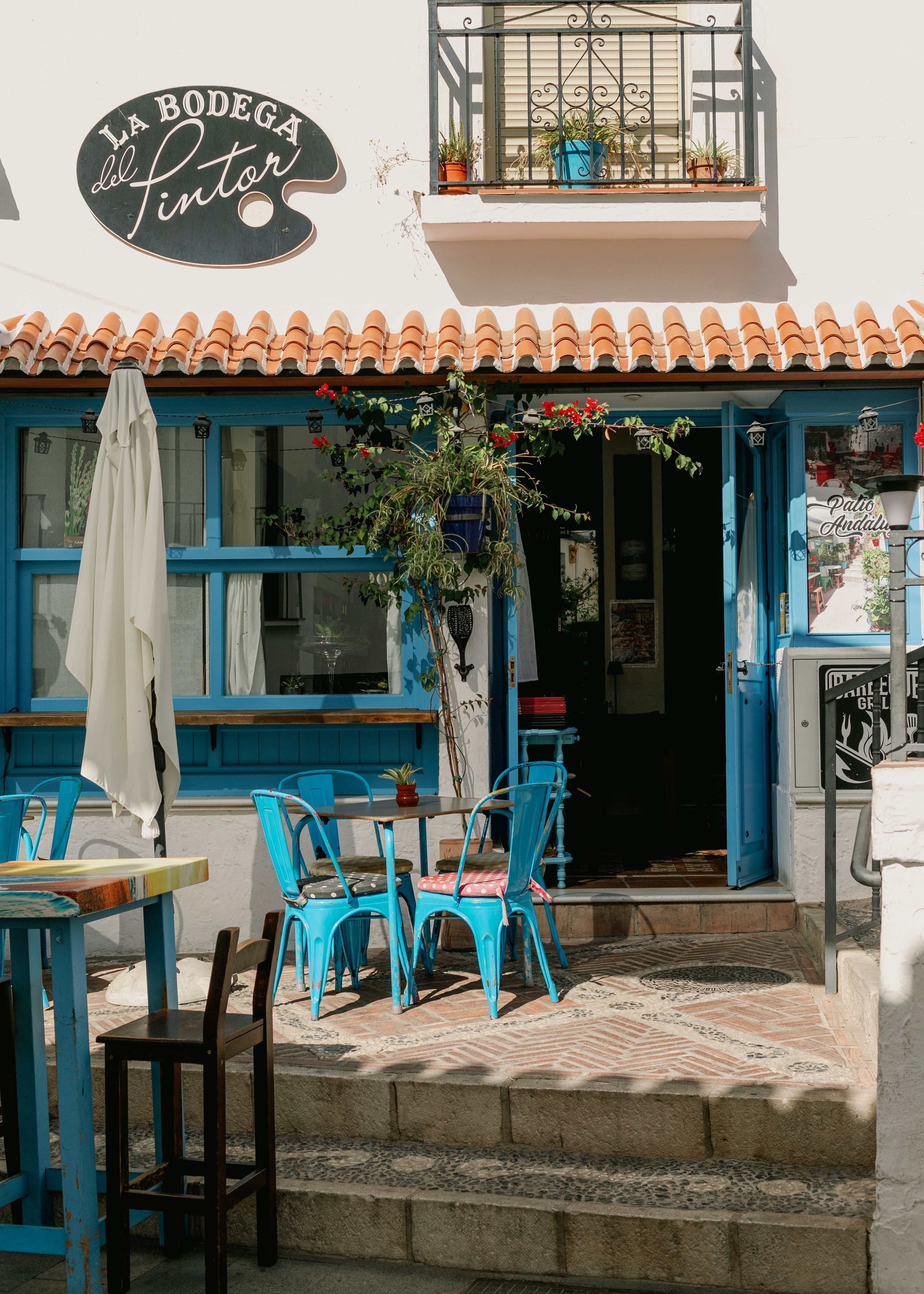 A restaurant with blue tables and chairs outside photo – Free Mijas ...