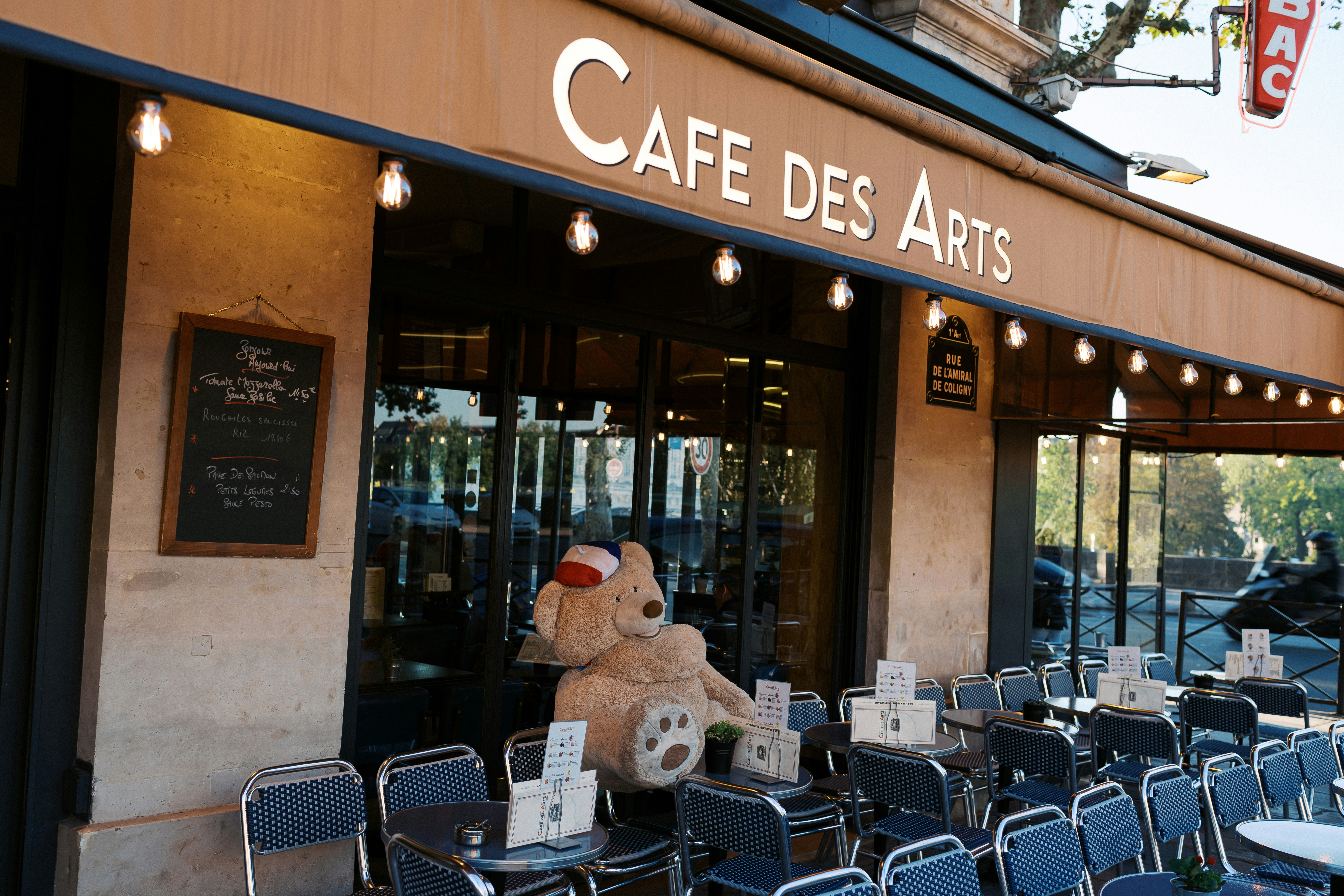 Teddy bear wearing French beret sitting in a Parisian café.
