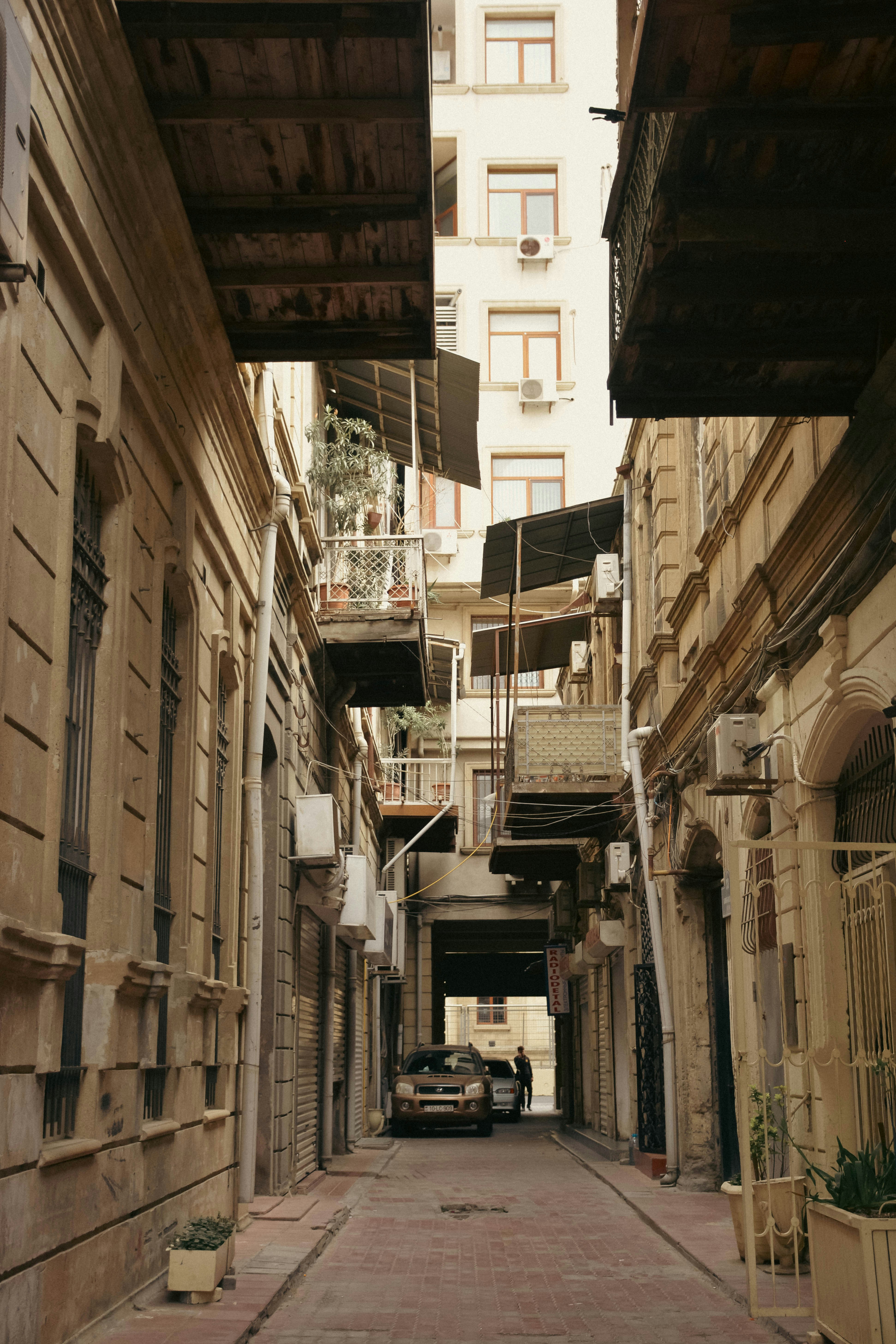 A narrow alley way with a car parked on the side