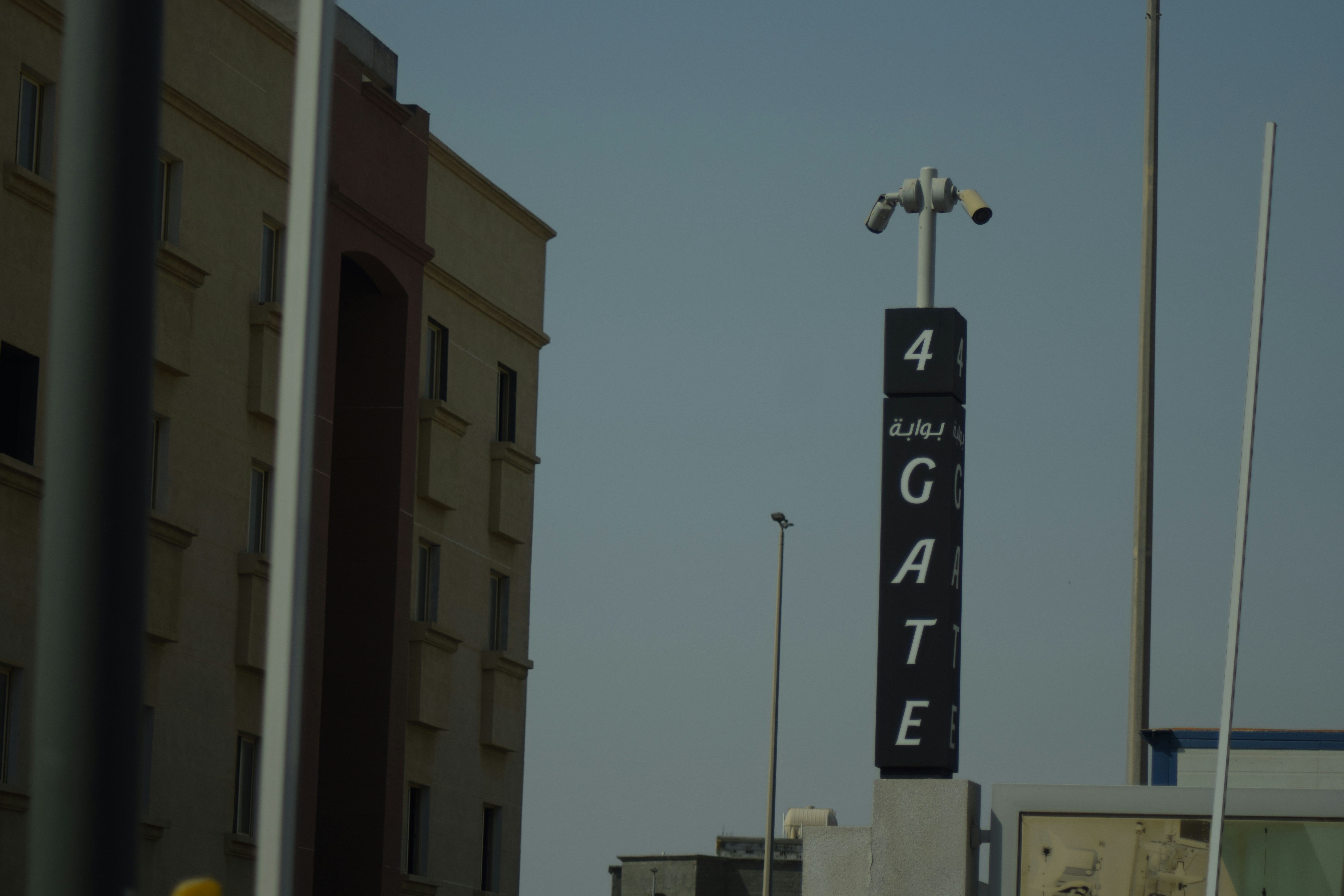 Vertical Gate Sign Rising Over a Quiet City Block