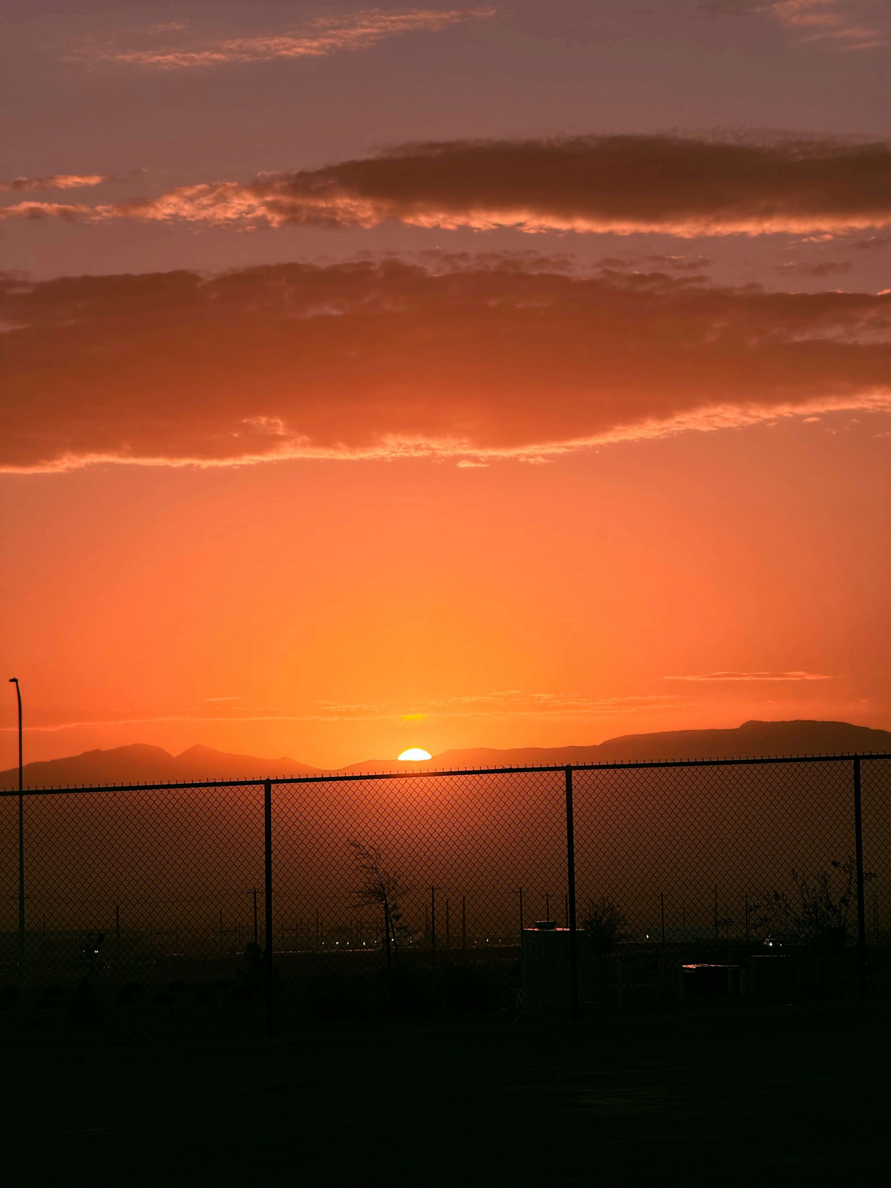 Sunset over the fence: a quiet glow at the edge of night