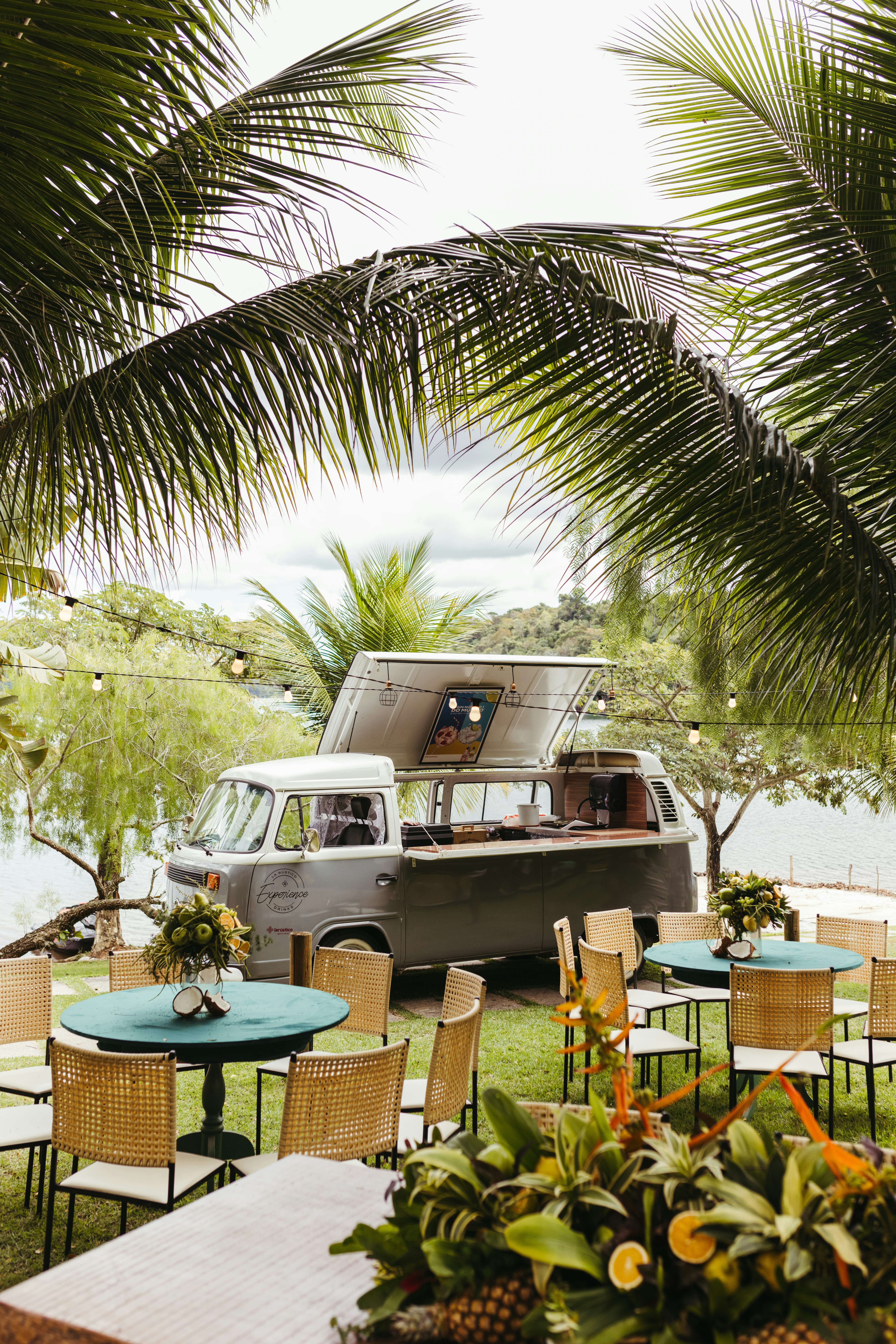 Palm-arched Lakeside Catering Van Under a Sunlit Canopy