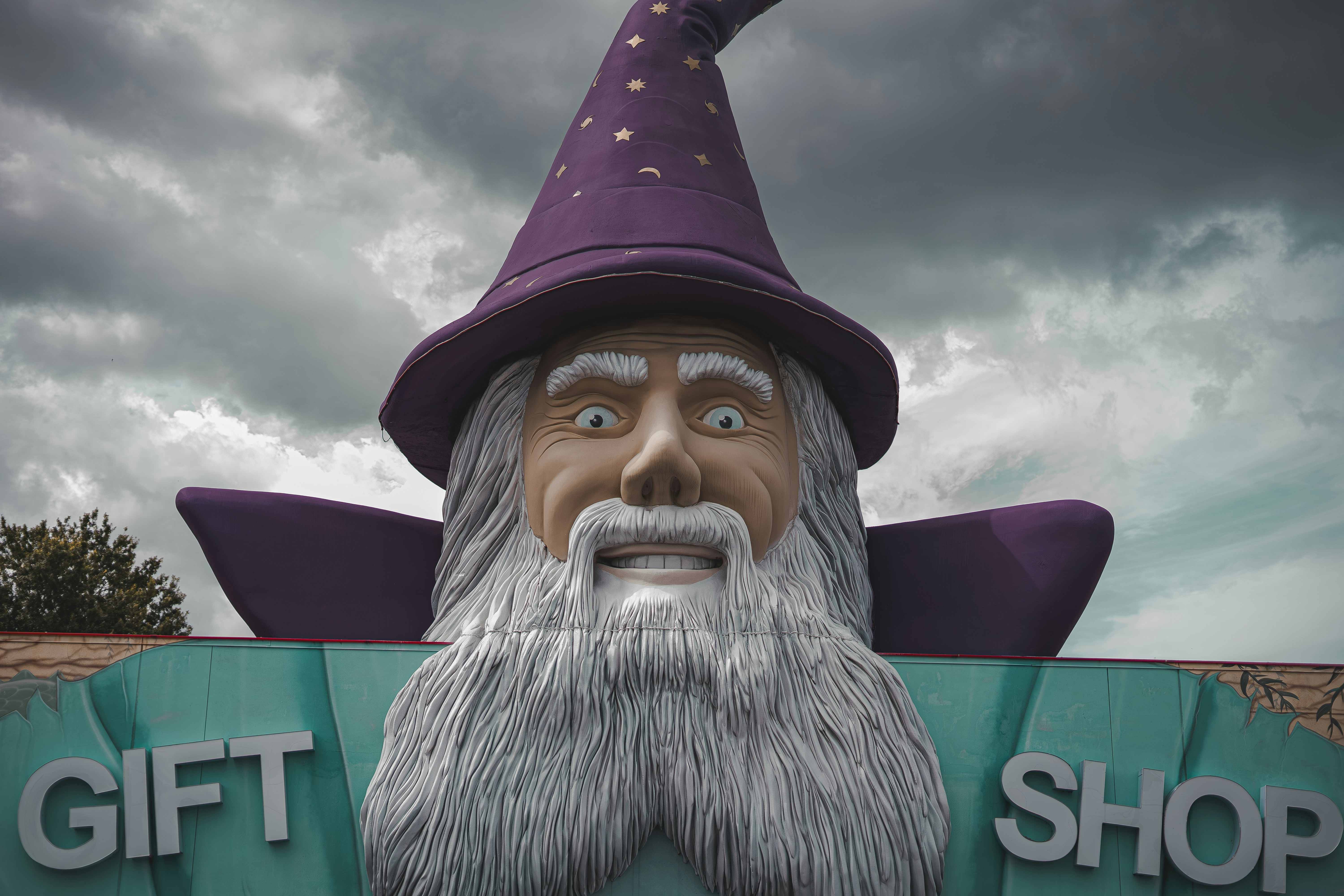 A statue of a wizard holding a sign that says gift shop photo – Free ...