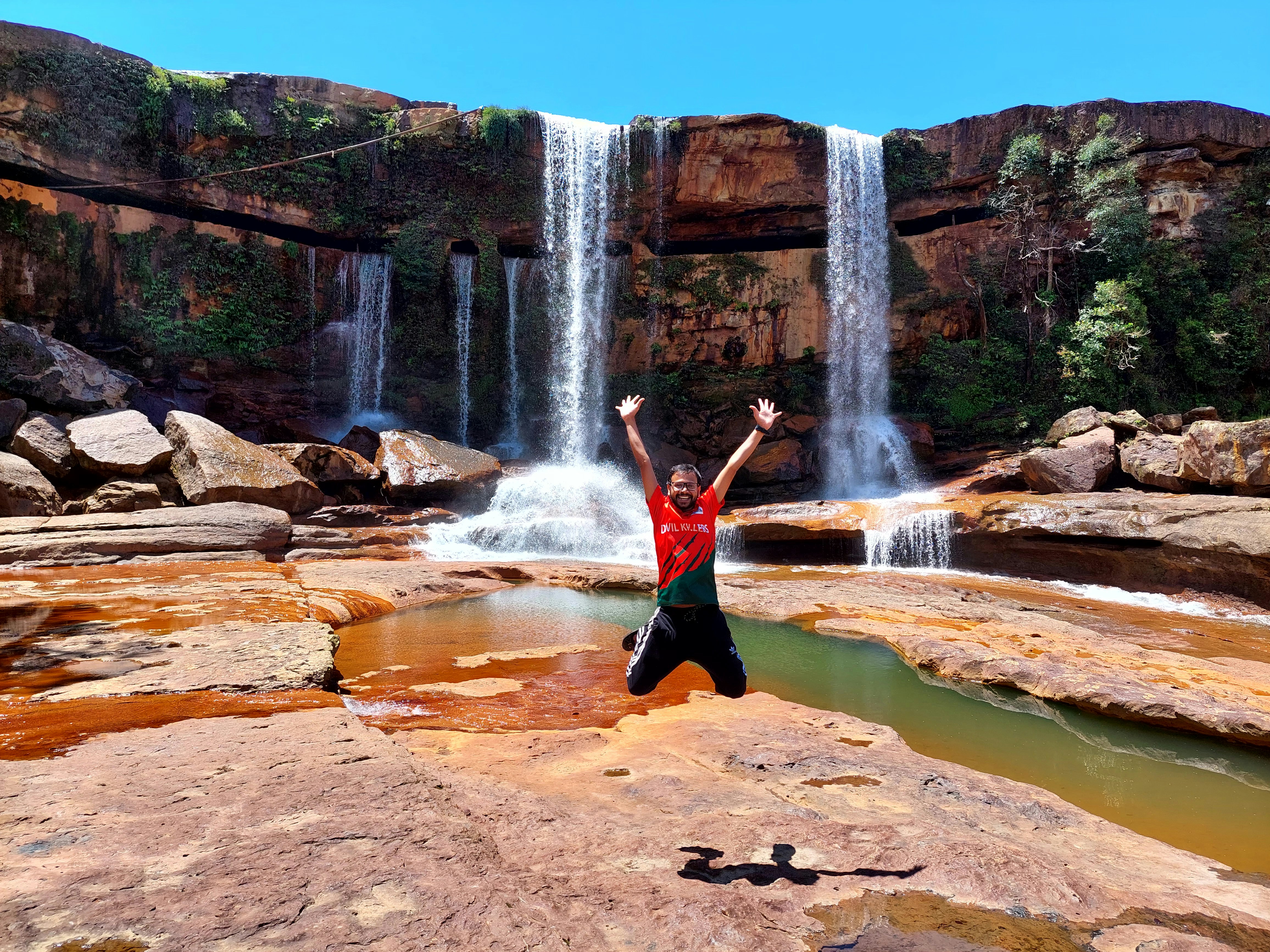 Jumping with Waterfall Backdrop: A Moment of Height and Joy