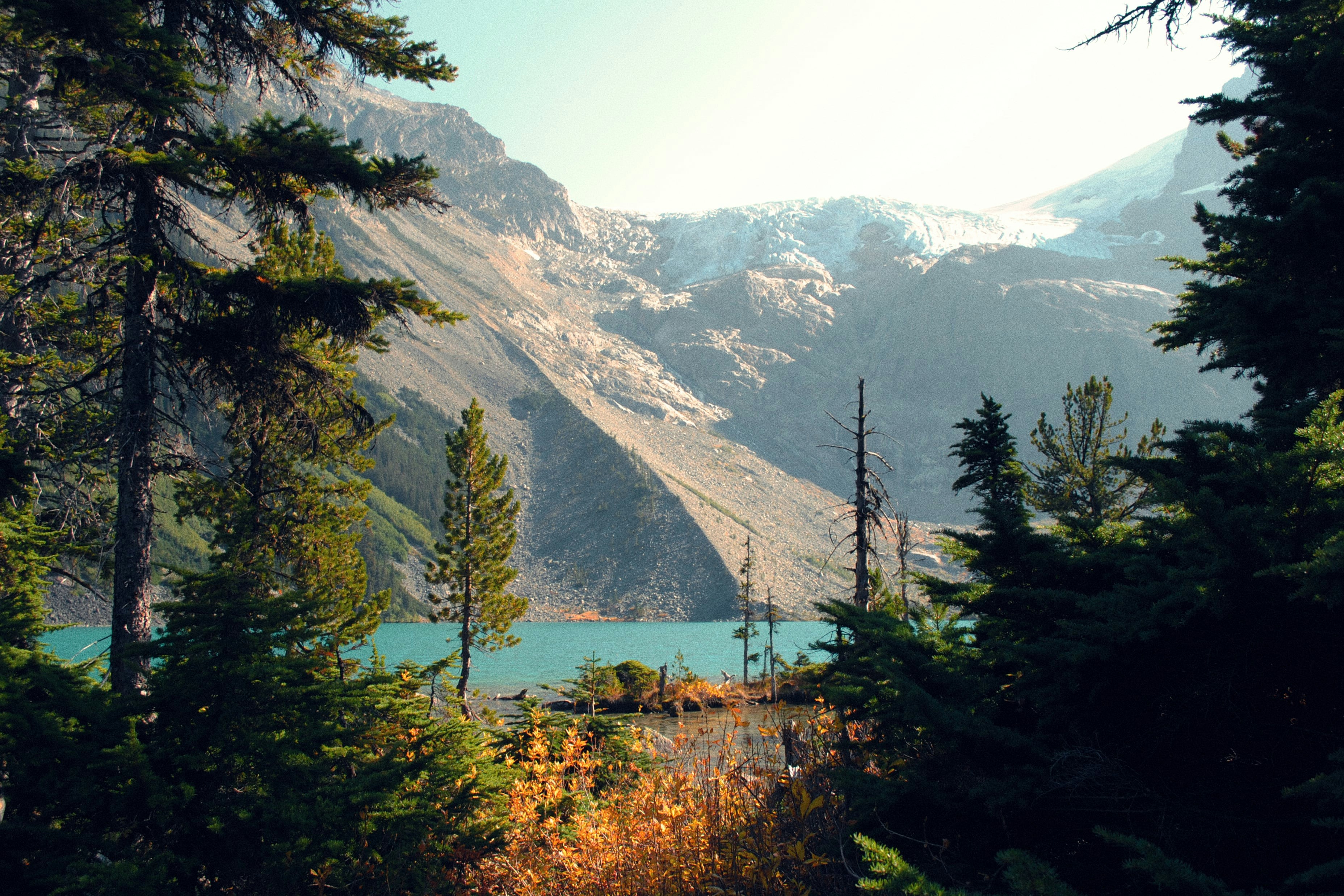 Emerald Alpine Lake Framed by Pines and Snow-Dusted Peaks