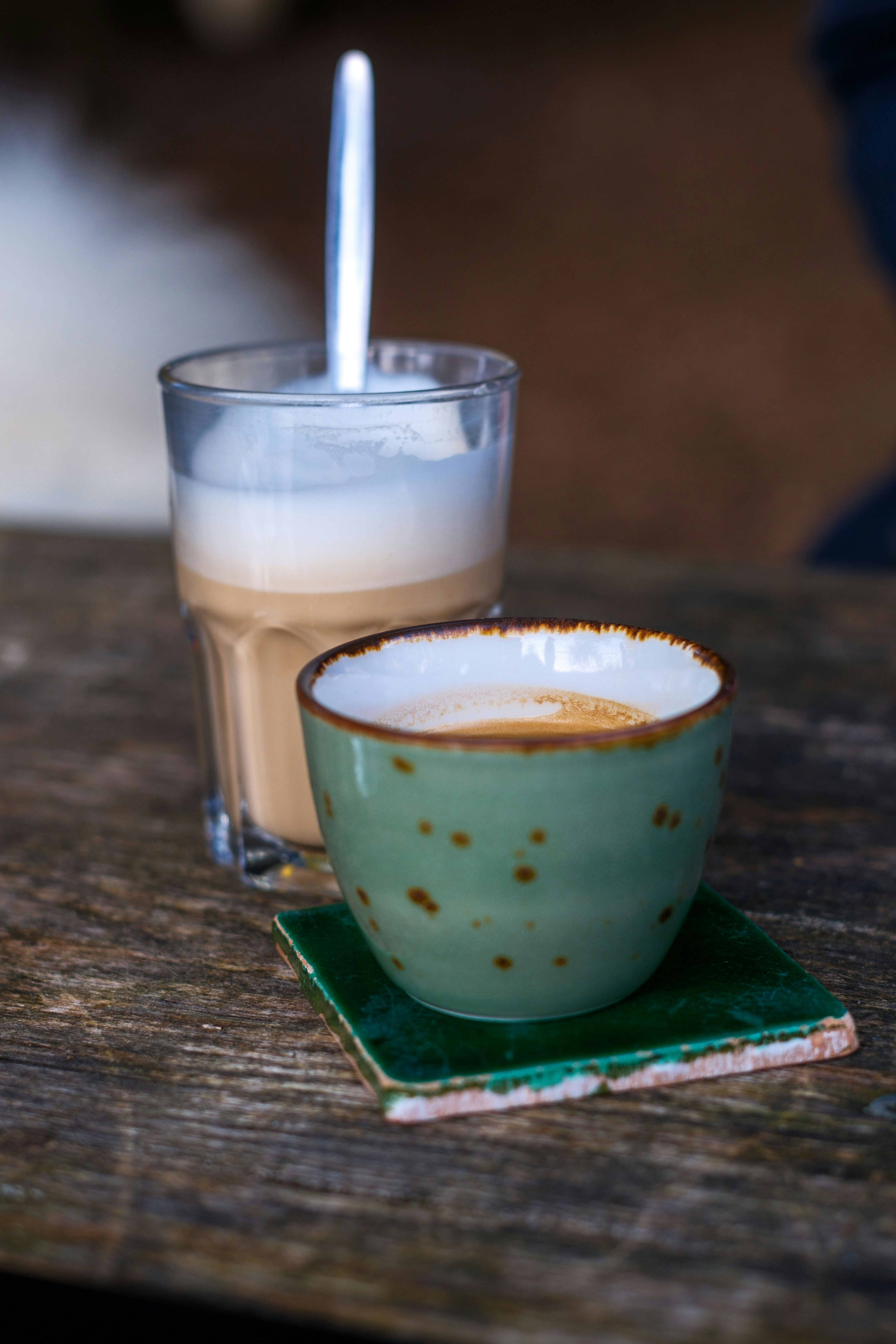 Speckled Teal Cup on Weathered Wood, Framed by a Creamy Latte