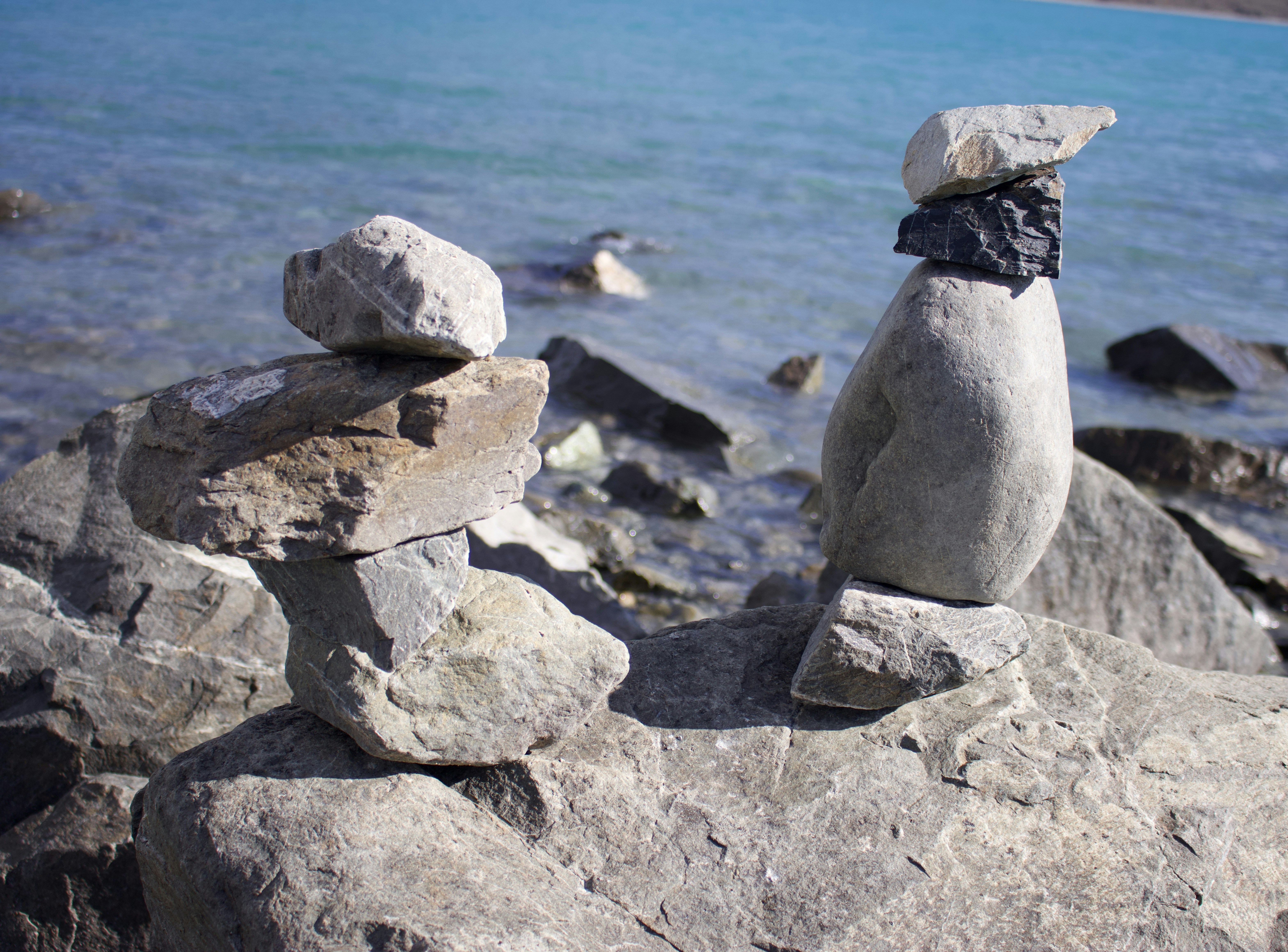 Balanced Stones by the Sea: a cairn framing calm turquoise shoreline