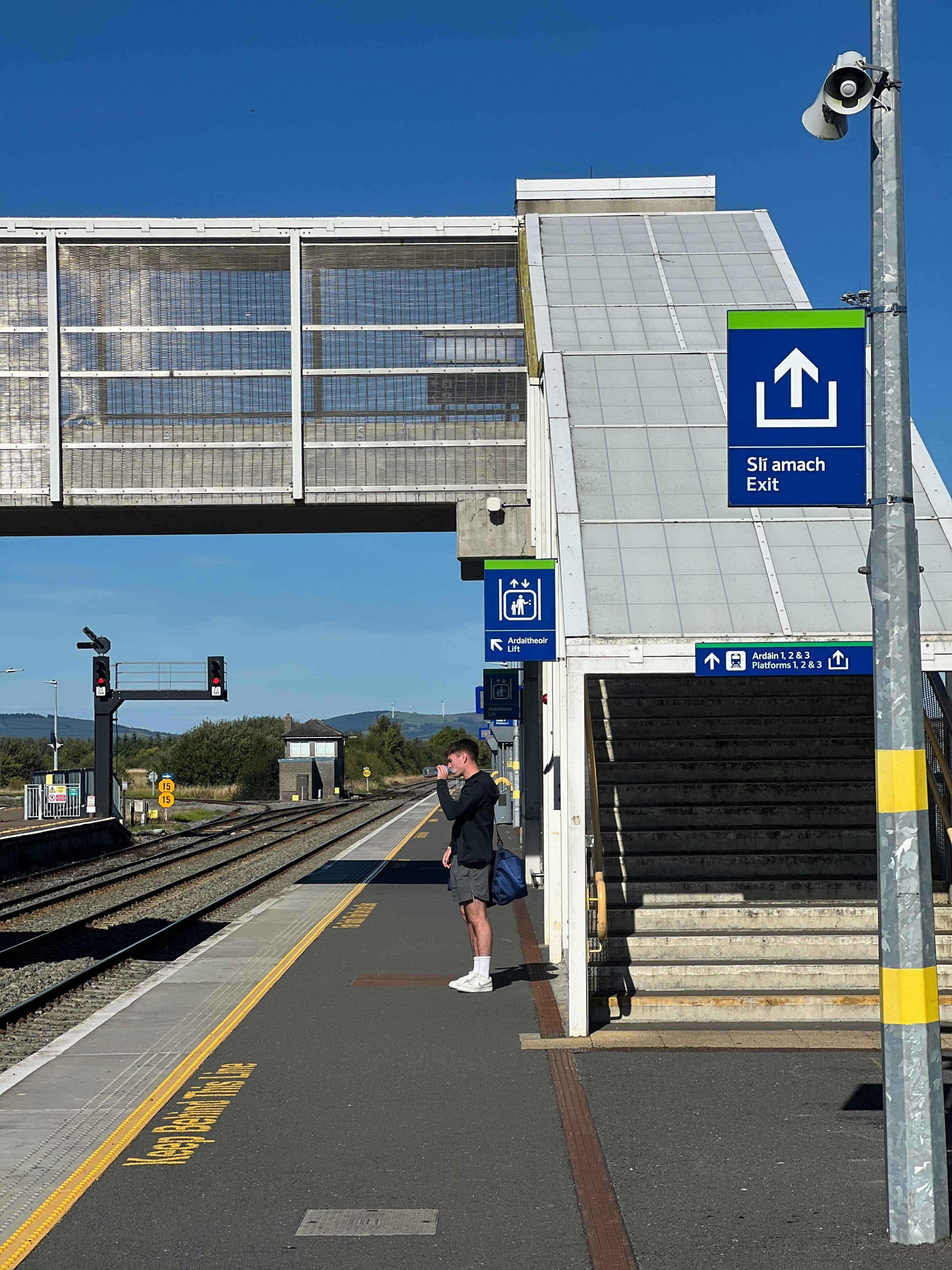 Platform Portrait: A Traveler Pauses at the Exit Sign