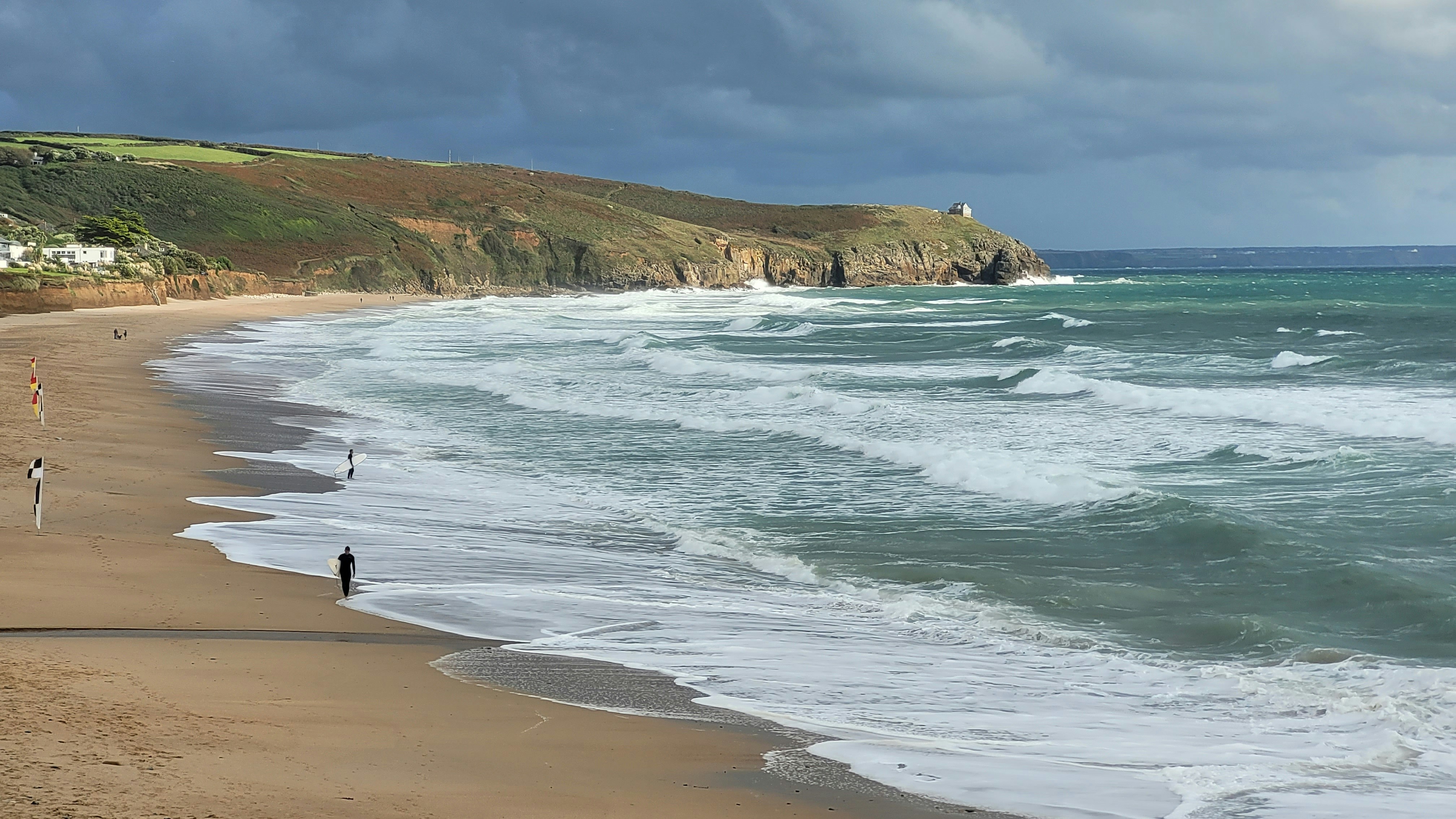 Cornwall, England UK | A sandy beach with waves coming in to shore