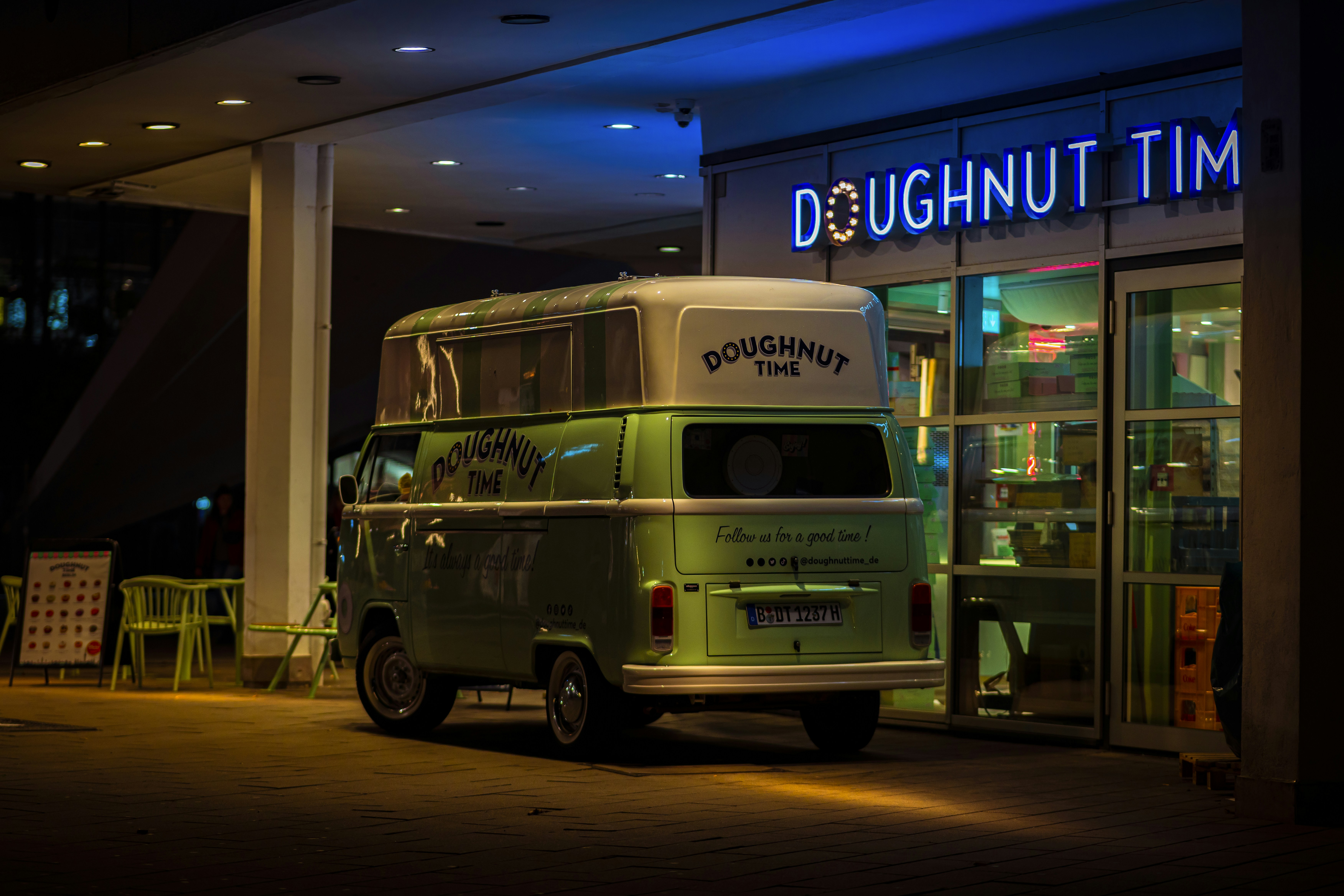 Mint-green vintage van under neon glow by Doughnut Time