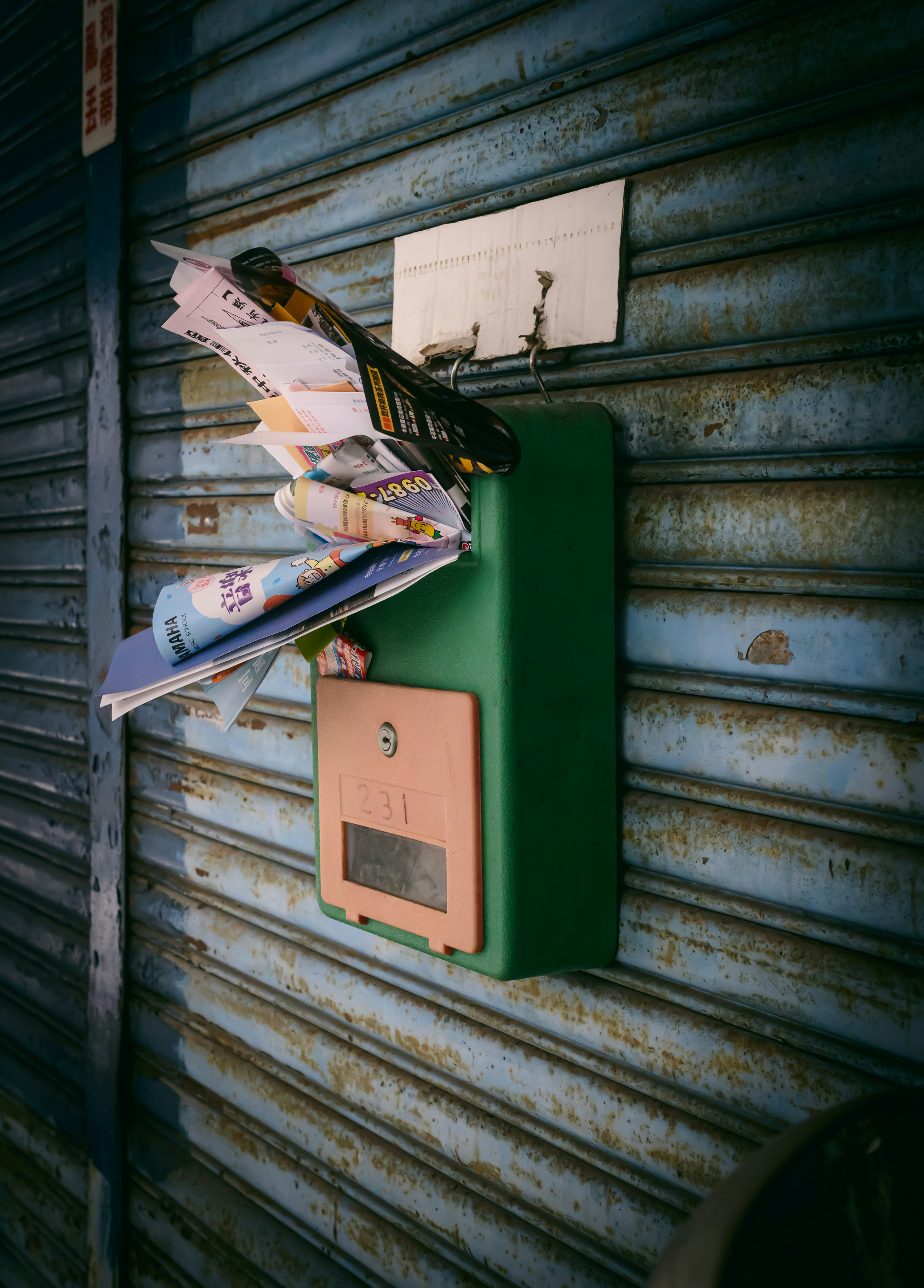 Headlines in a Green Mailbox: News Bursts from a Weathered Shutter