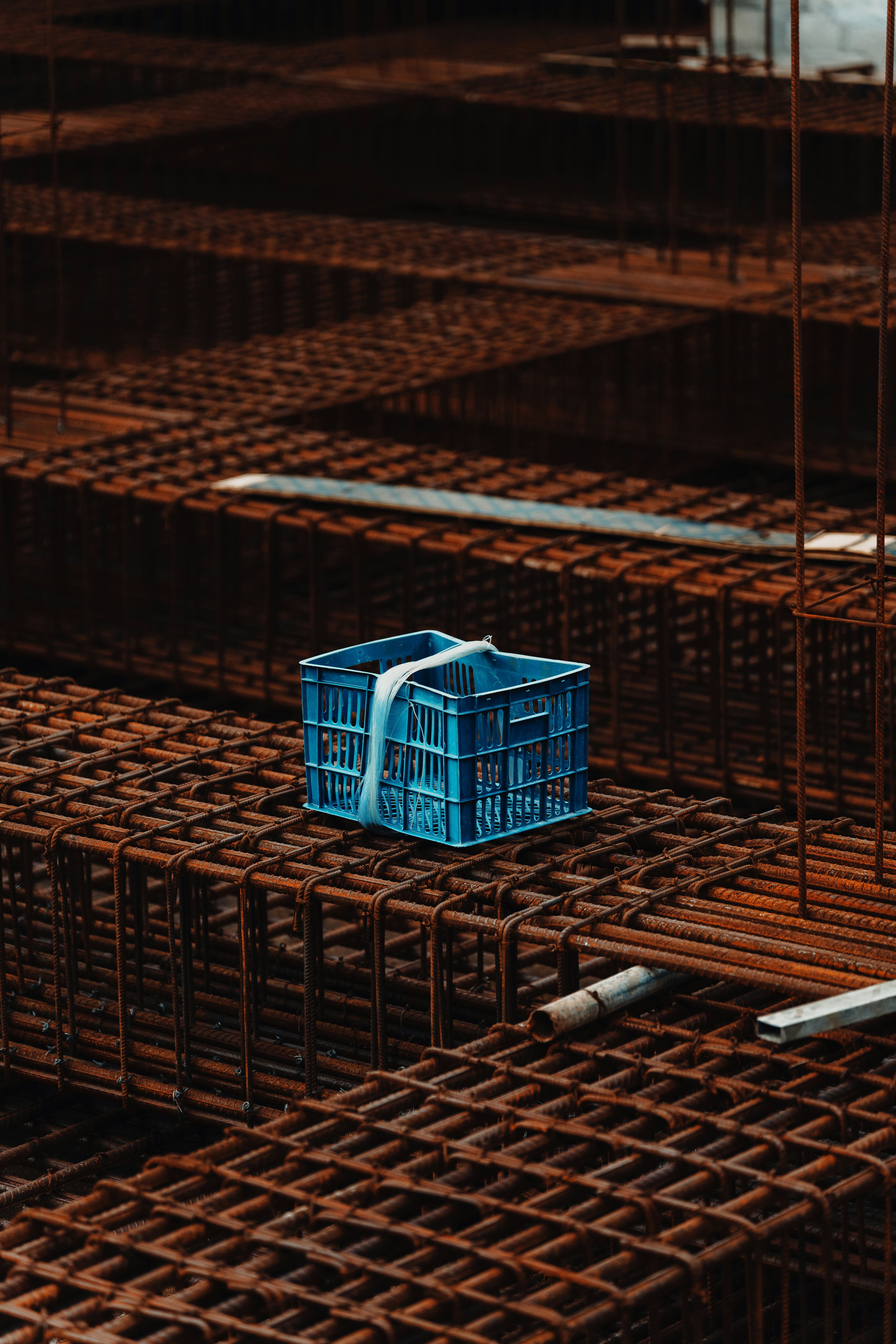 A blue crate sitting on top of a pile of steel bars photo – Free ...