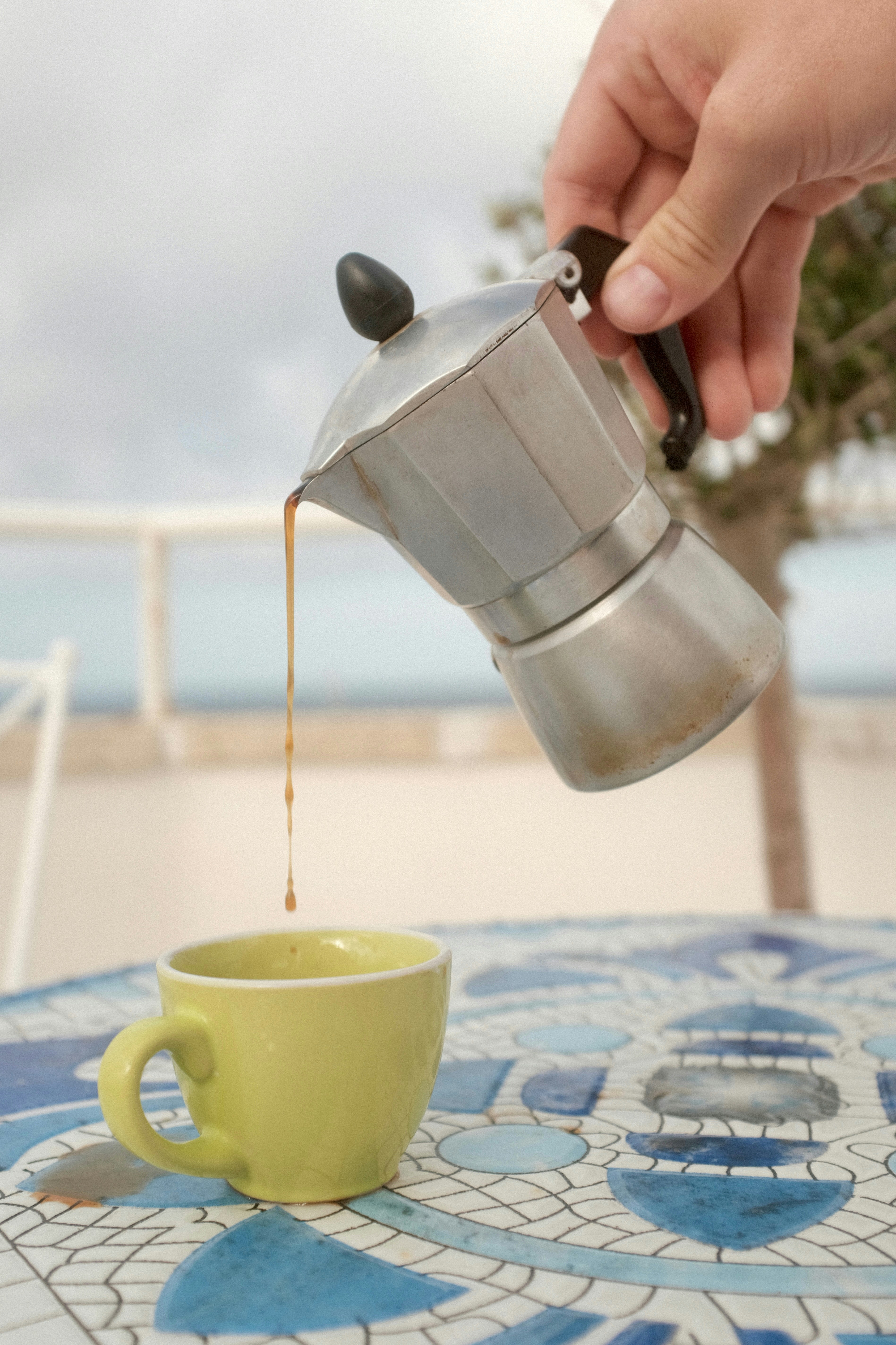Moka Pour Over a Blue Mosaic Table by the Sea