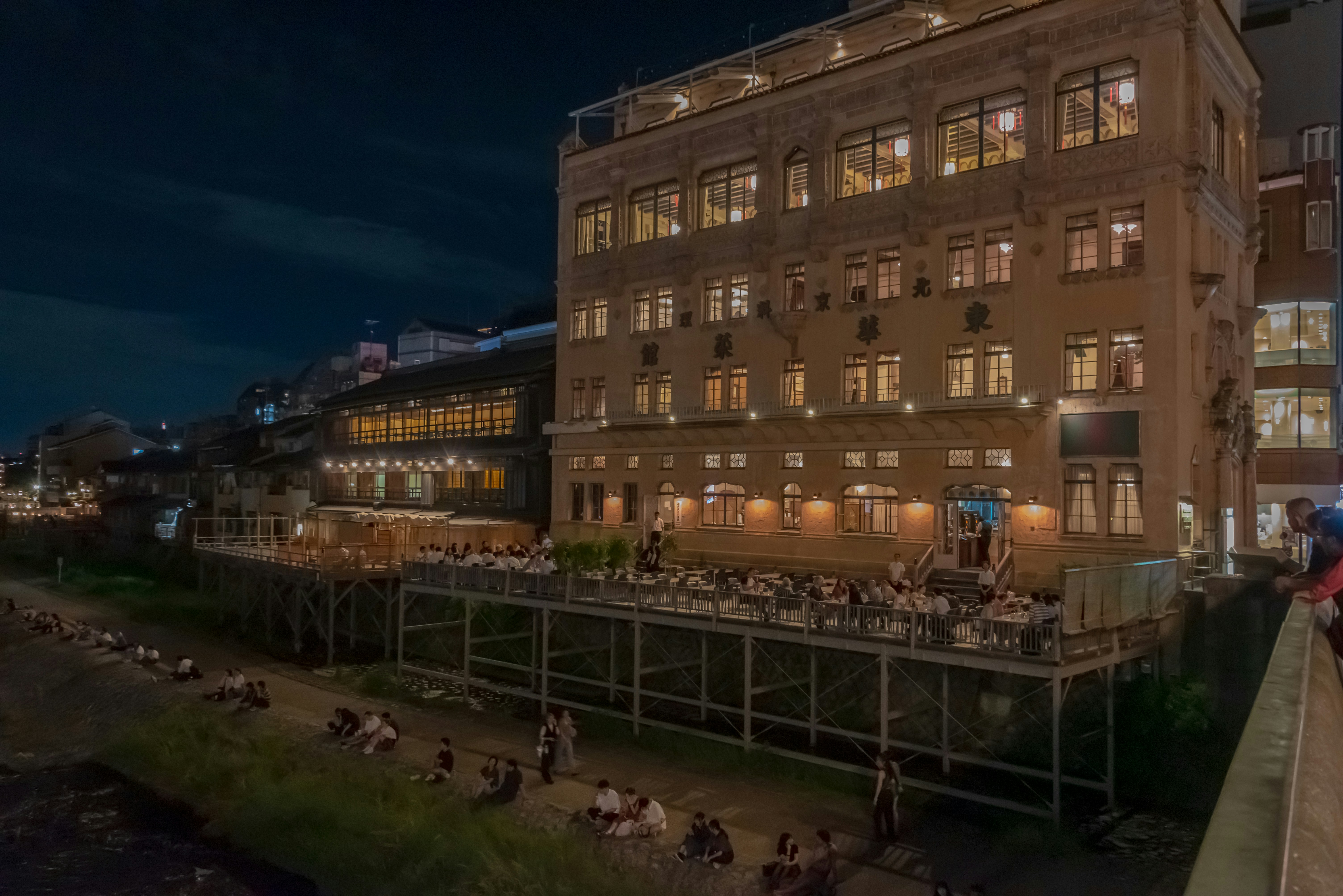 Night Waterside Café Under Warm Windows