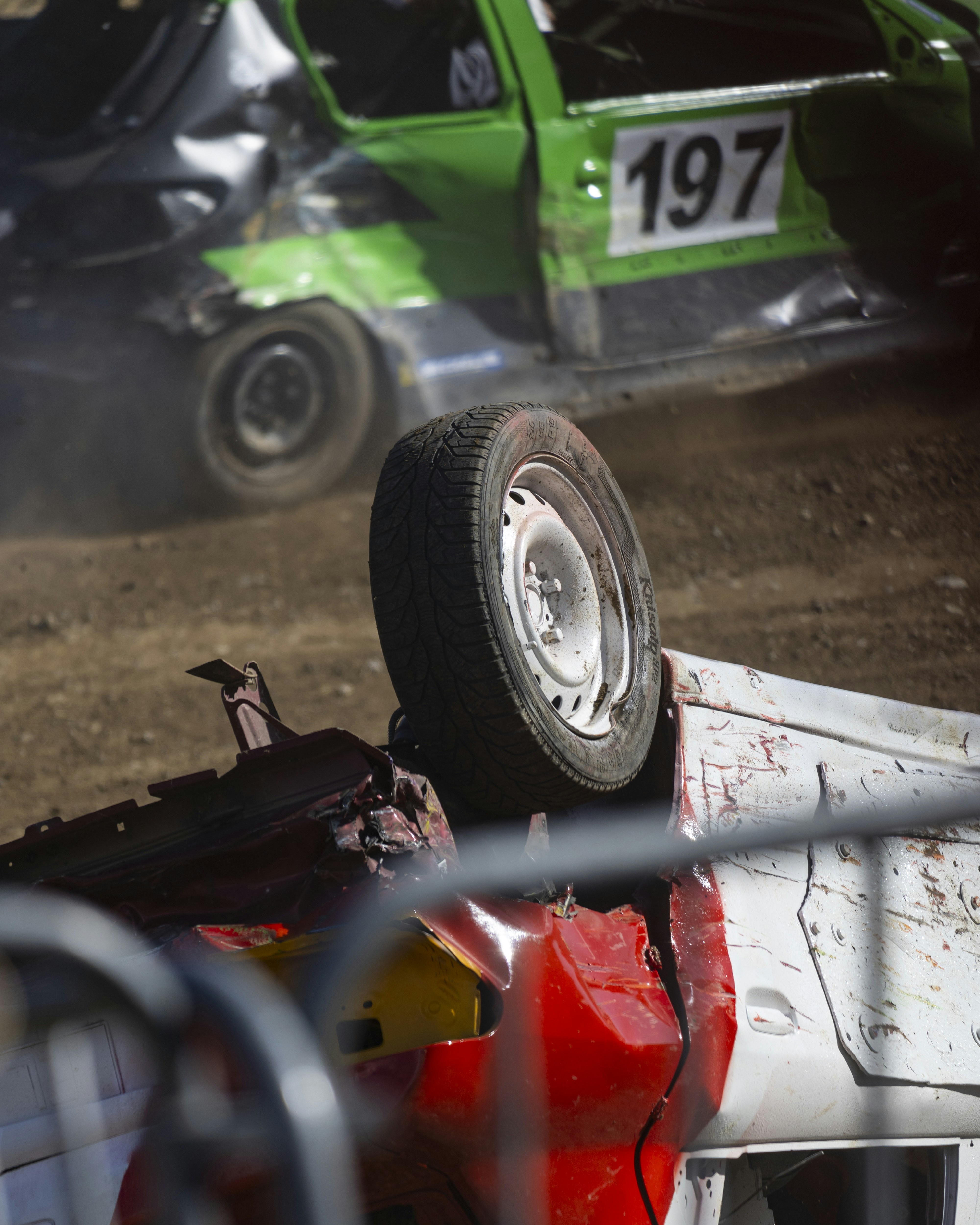 Crushed Competition: A Green Rally Car meets its Match as a Spare Wheel Collides with the Dirt