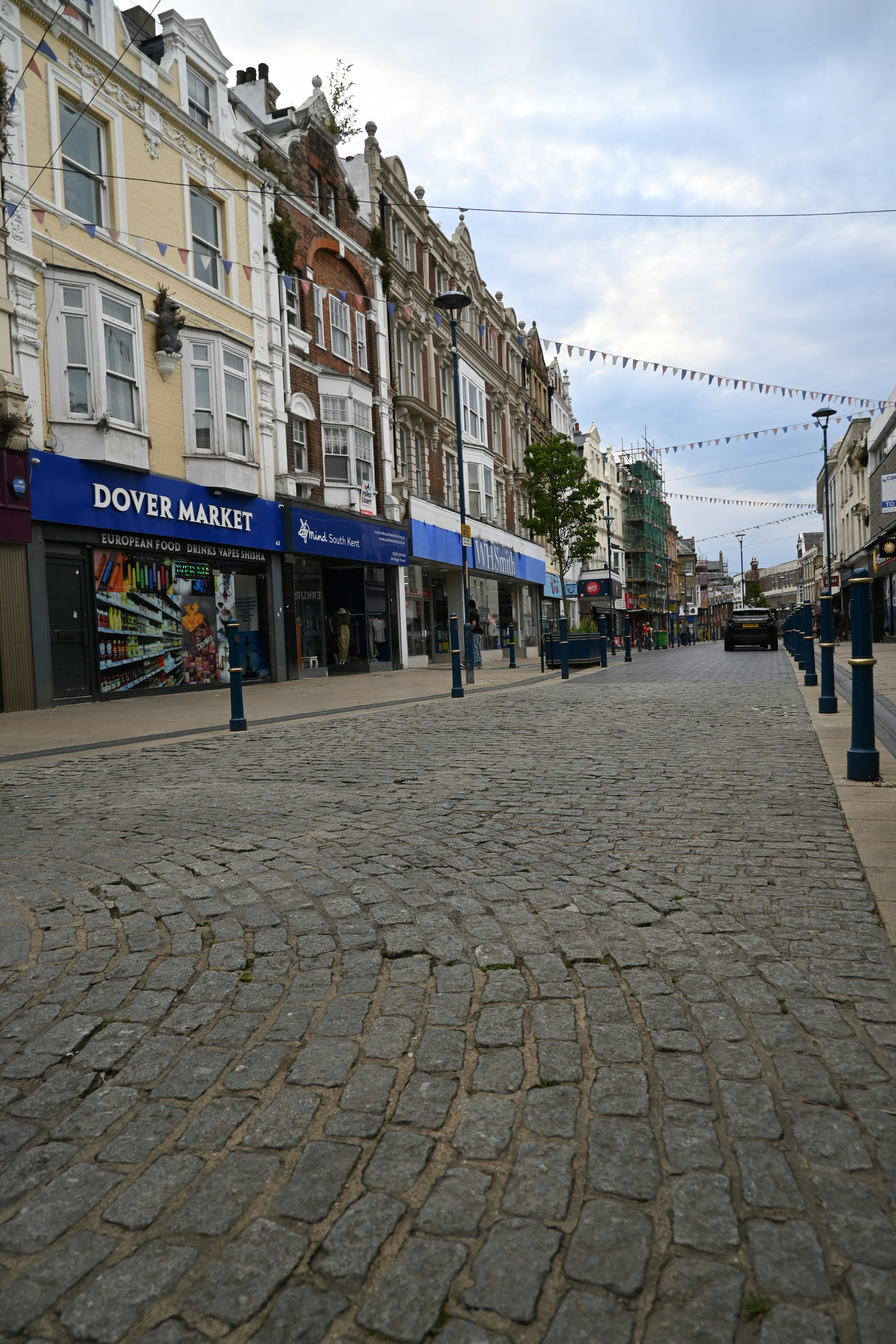 A cobblestone street lined with buildings and shops