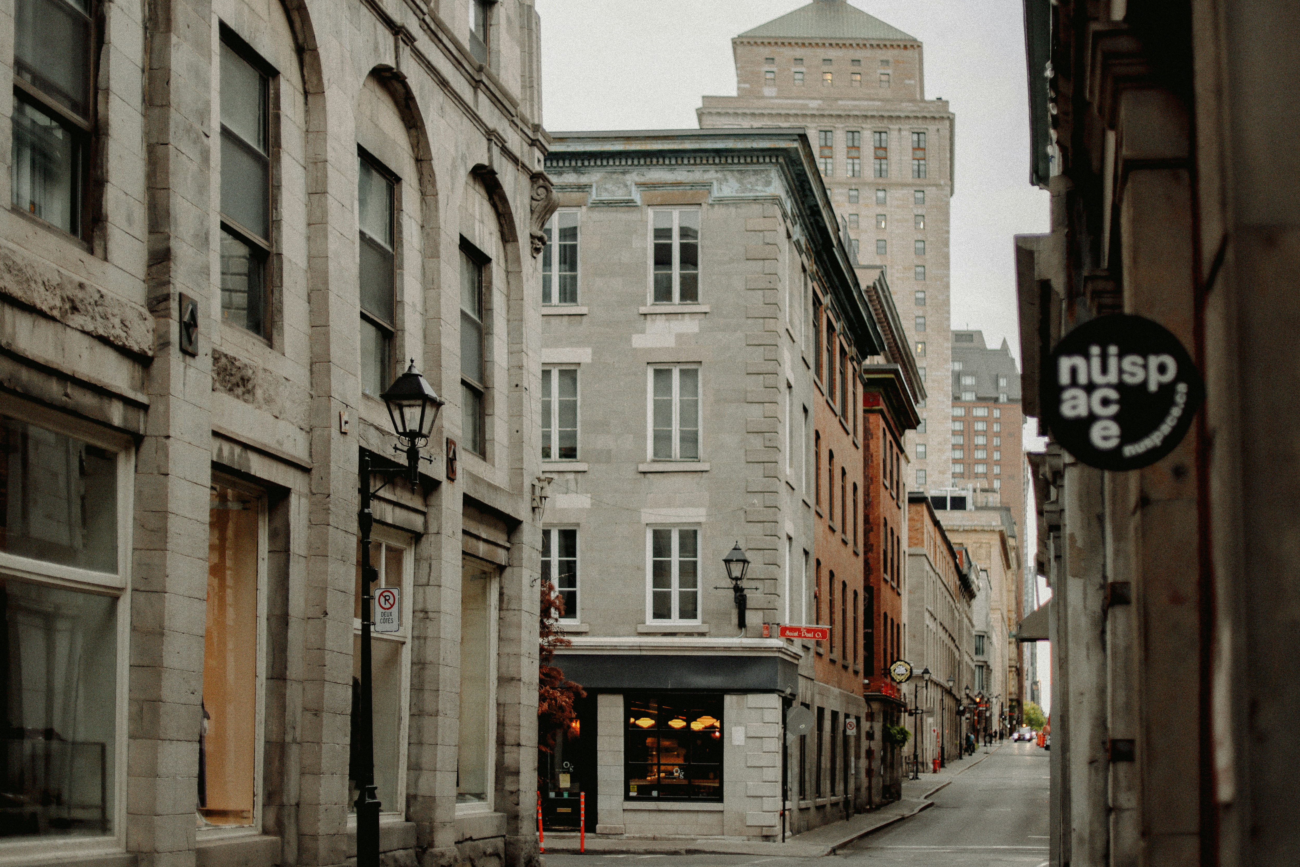 A narrow city street with buildings on both sides photo – Free Street ...