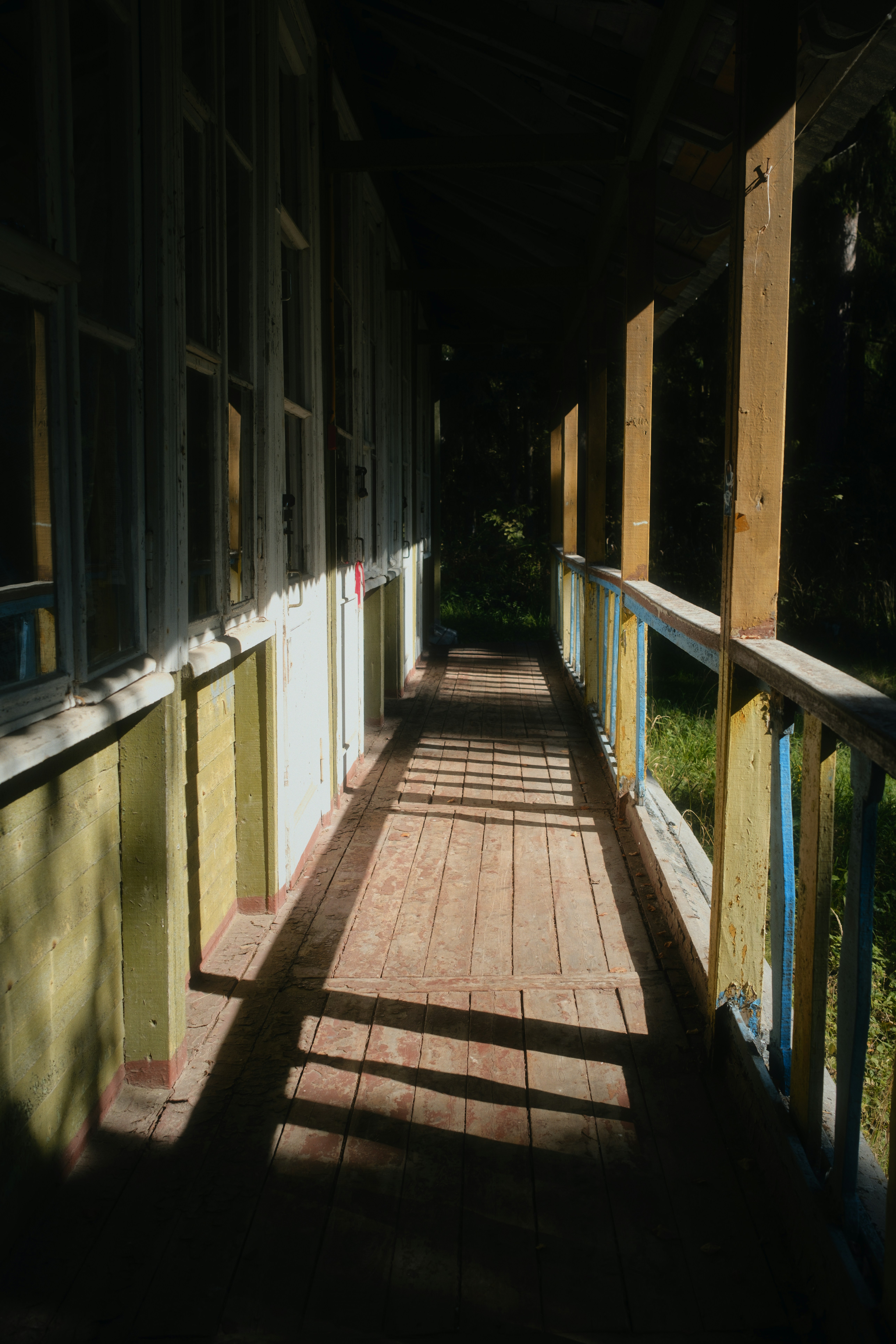 Sunlit Veranda Corridor: A Vanishing Path of Wood and Shadow