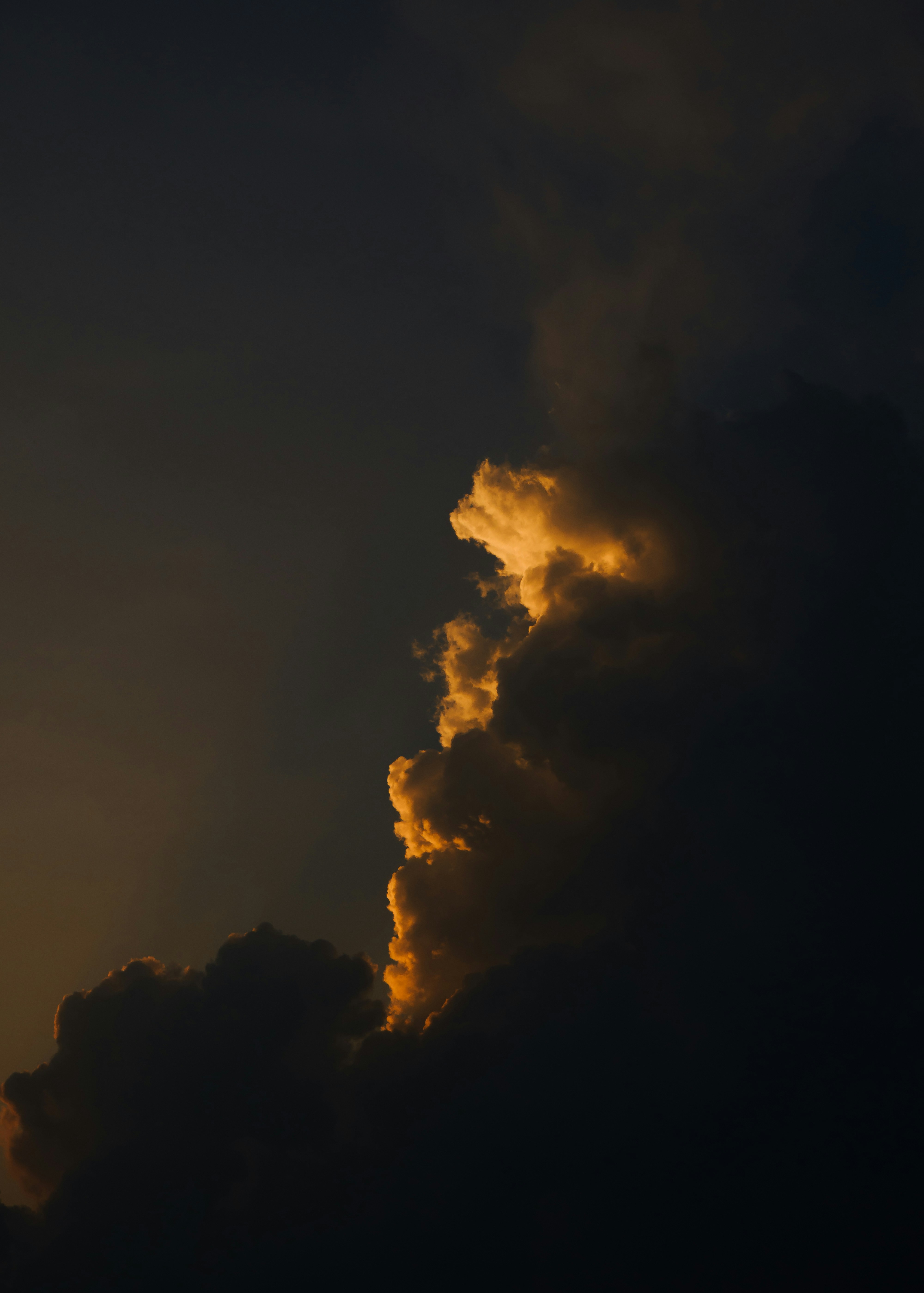 Ember Edge at Dusk: A Sunlit Cloud Slice Rises Against the Night
