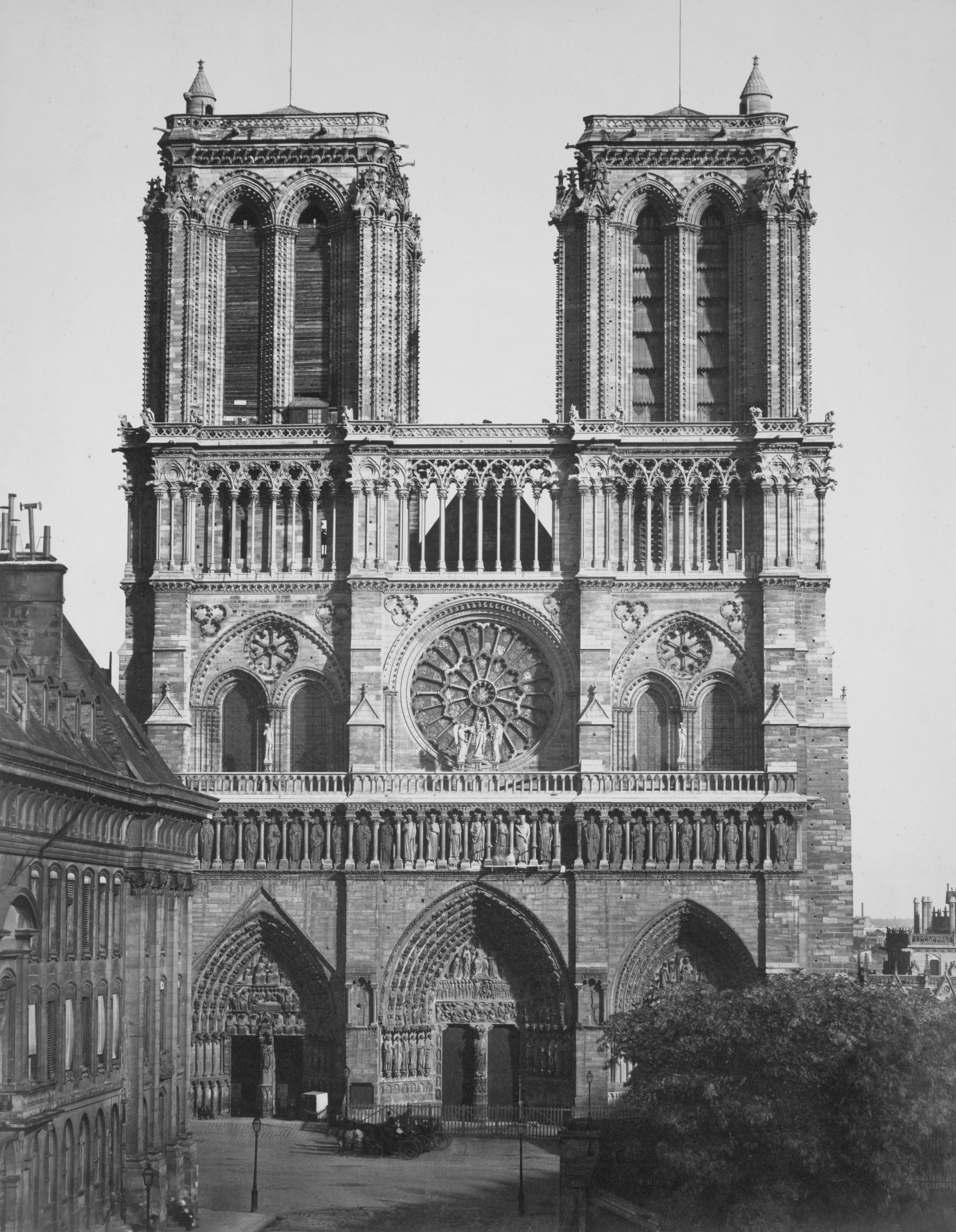 Monochrome photograph capturing Notre-Dame’s façade, highlighting the rose window and twin towers with intricate stonework.