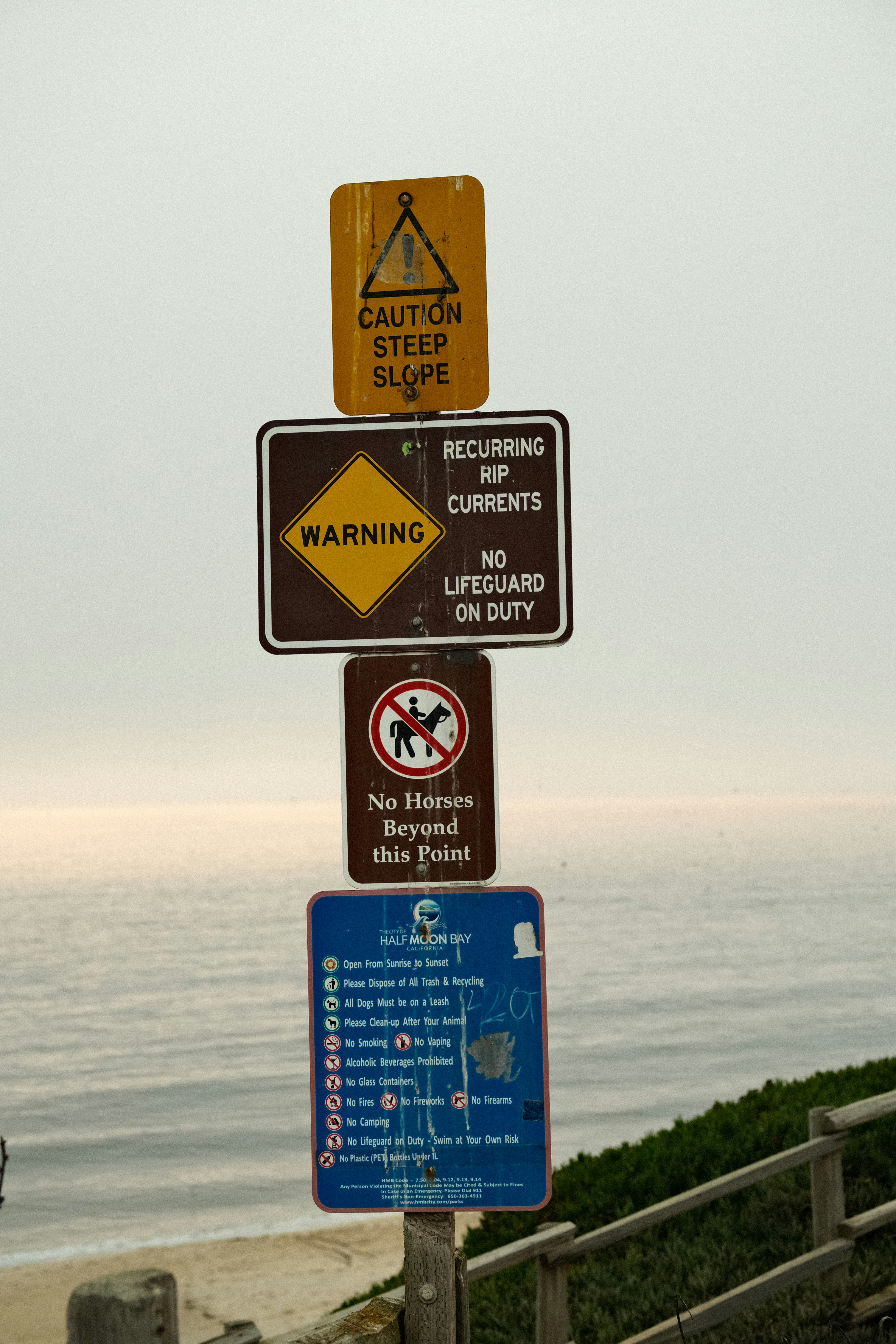 Seaside Signpost Stack: Caution by the Shore