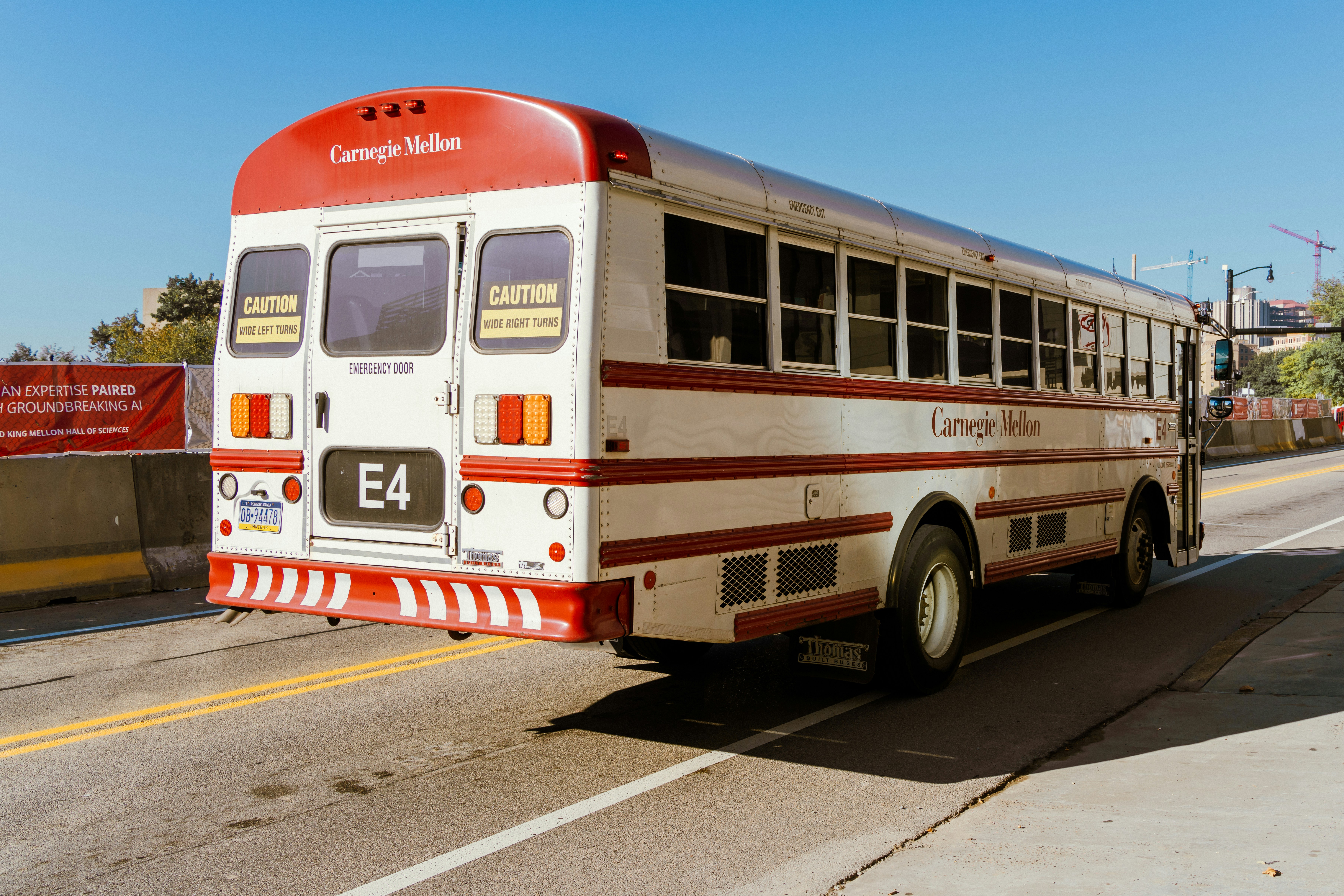 E4 on the Street: A Vintage White-and-Red Bus Basking in Noon Sun