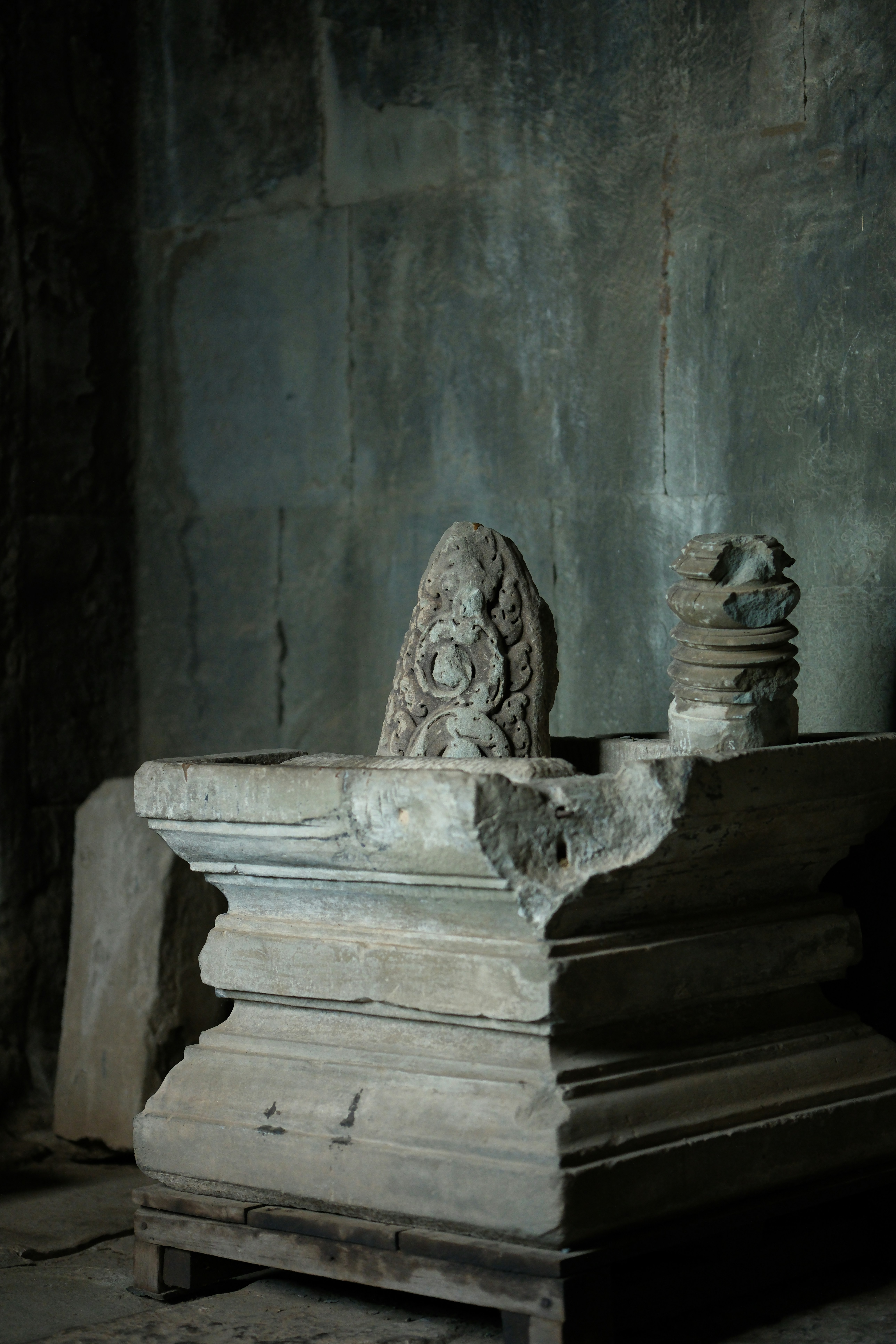 Carved Finial in a Dim Ruin: Weathered Stone on a Sacred Pedestal