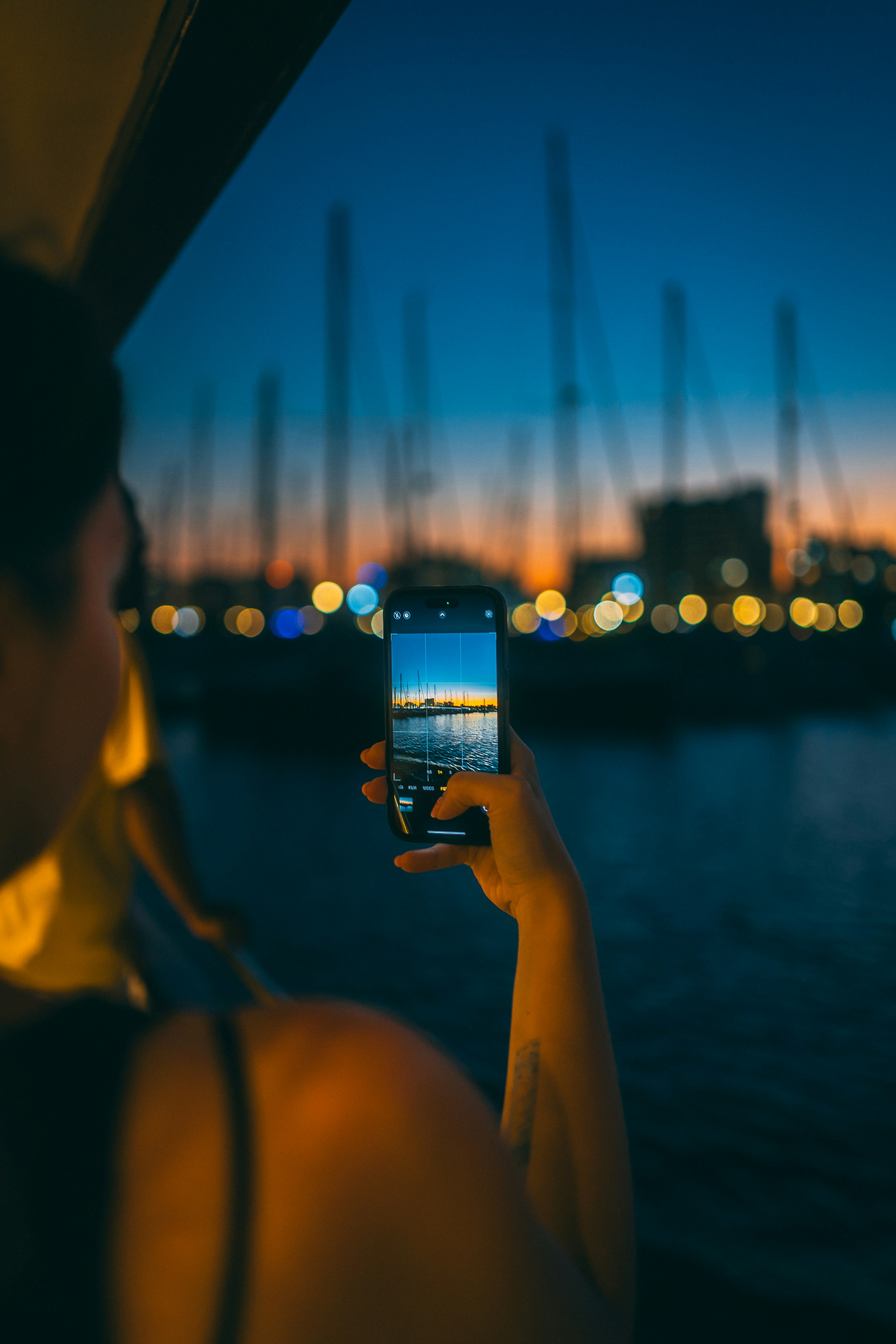A woman taking a picture of a city at night photo – Free Larnaca Image ...