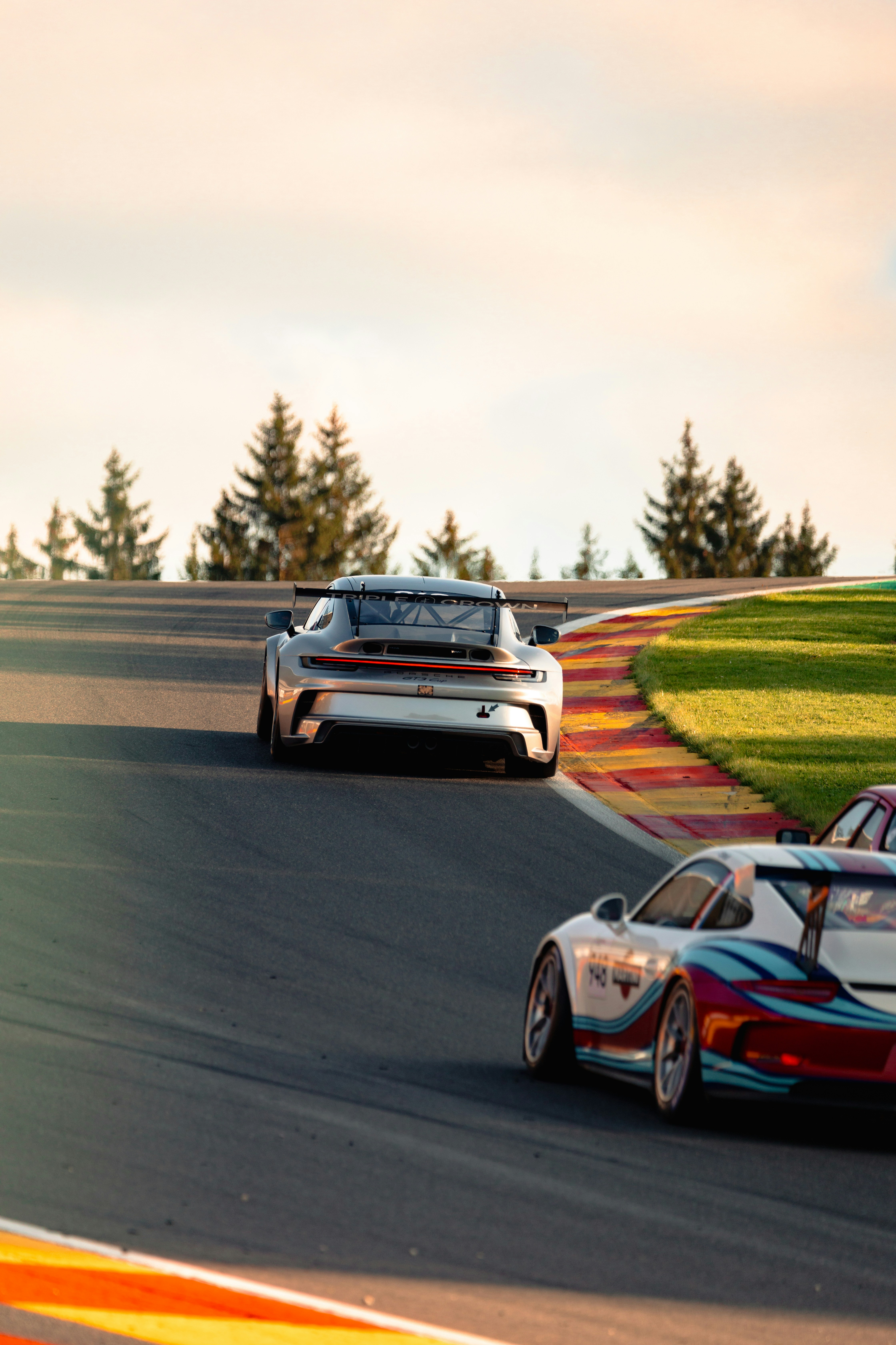 A couple of cars driving down a race track photo – Free Automobile ...