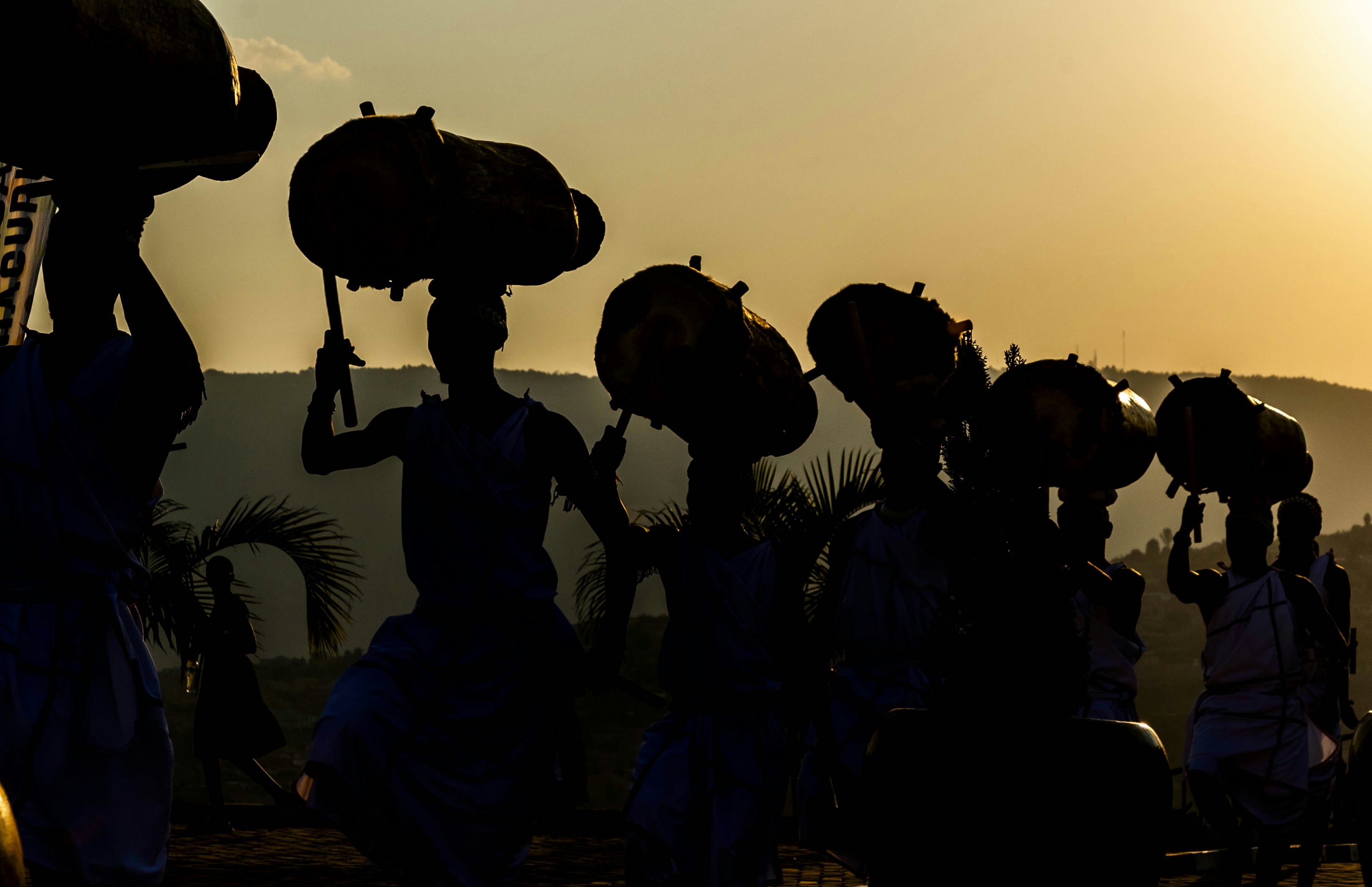 Burundian cultural troup performing in Africa Haguruka 2023. | A group of people with umbrellas standing in the sun