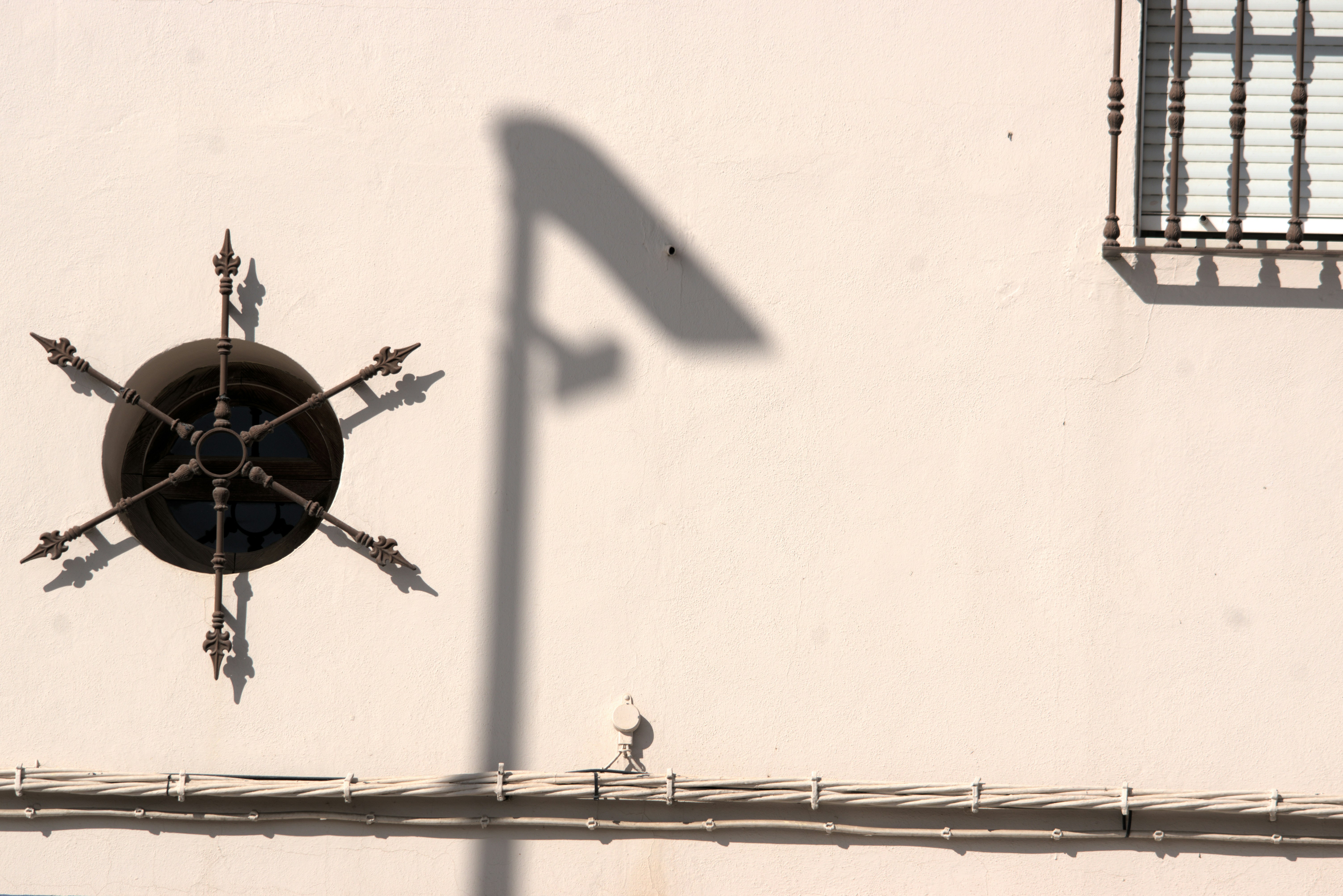 Shadow and Spokes on a Sunlit Facade