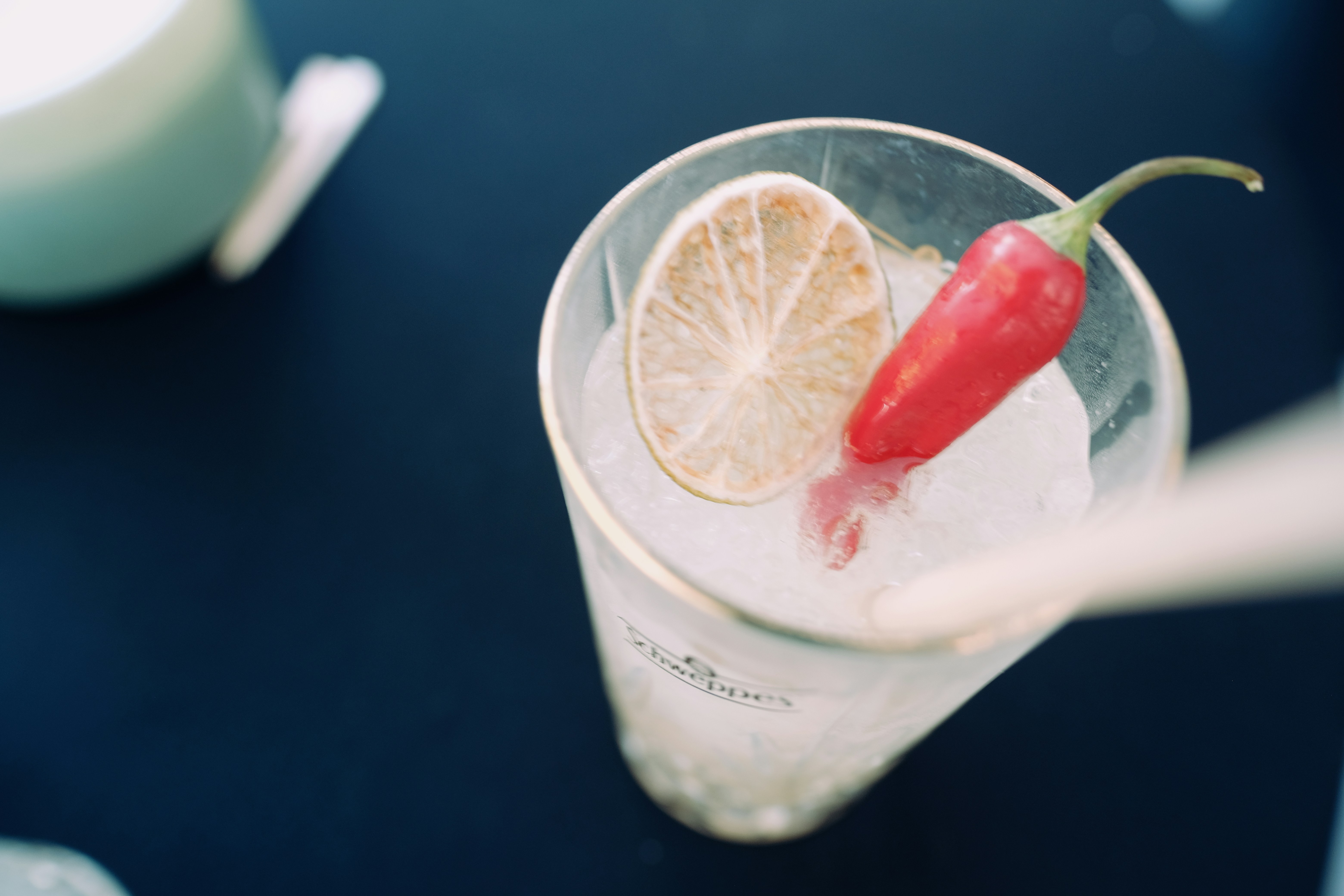 Citrus Splash: A Chill Glass with Lime Slice and Red Pepper Garnish