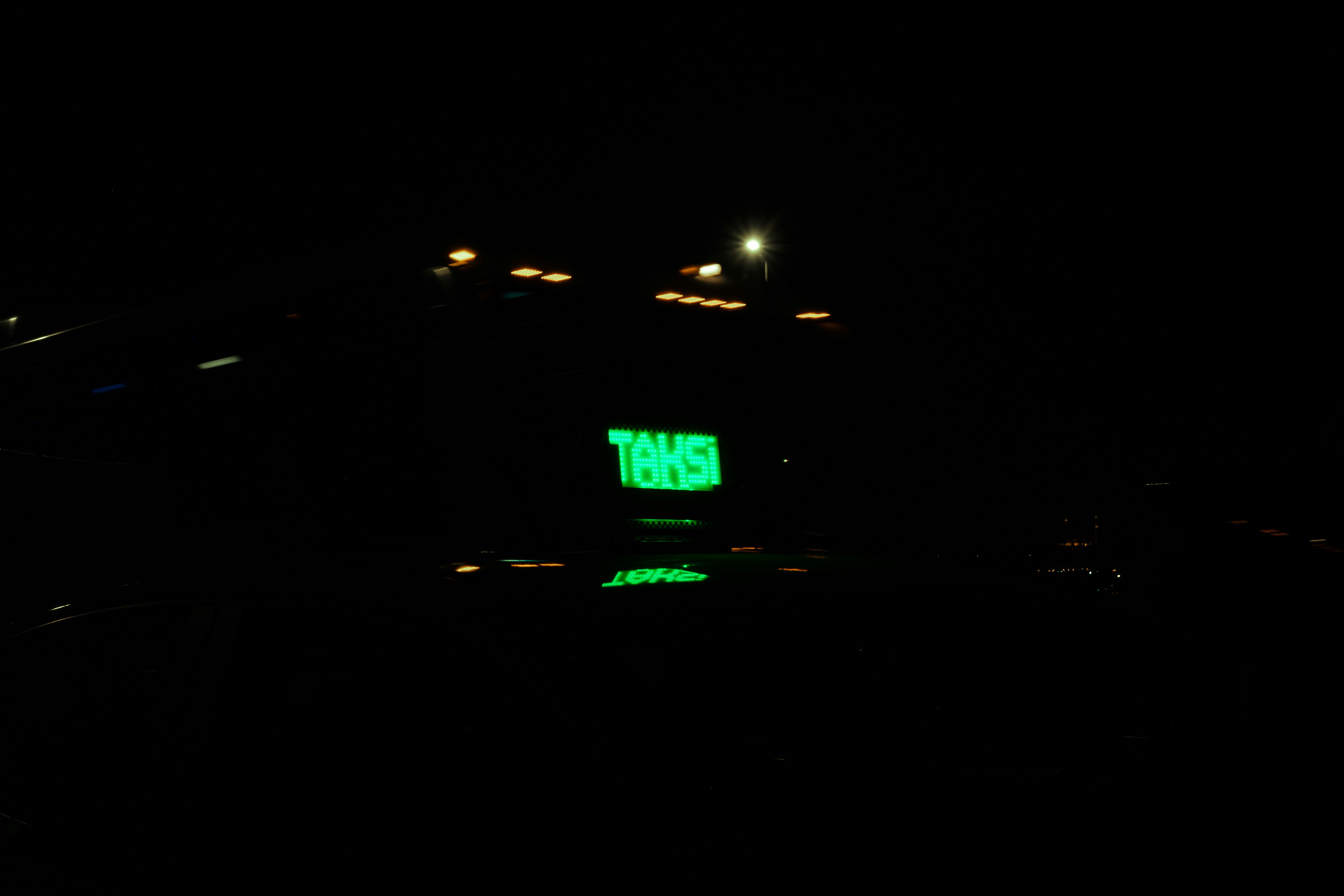 Neon Green Taxi Sign Pierces the Night