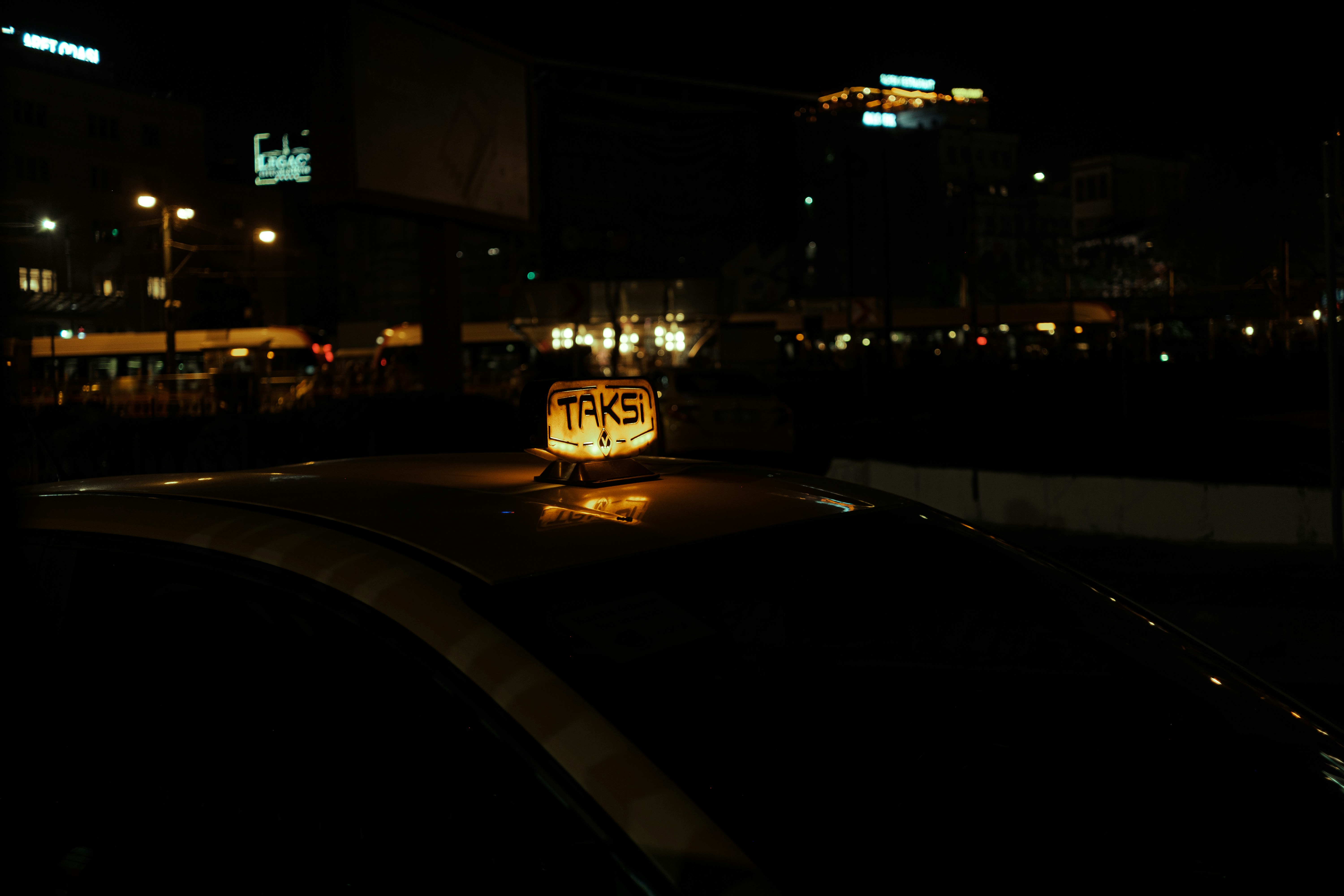 Midnight Beacon: A Taxi Sign Glowing Over a Quiet City Night