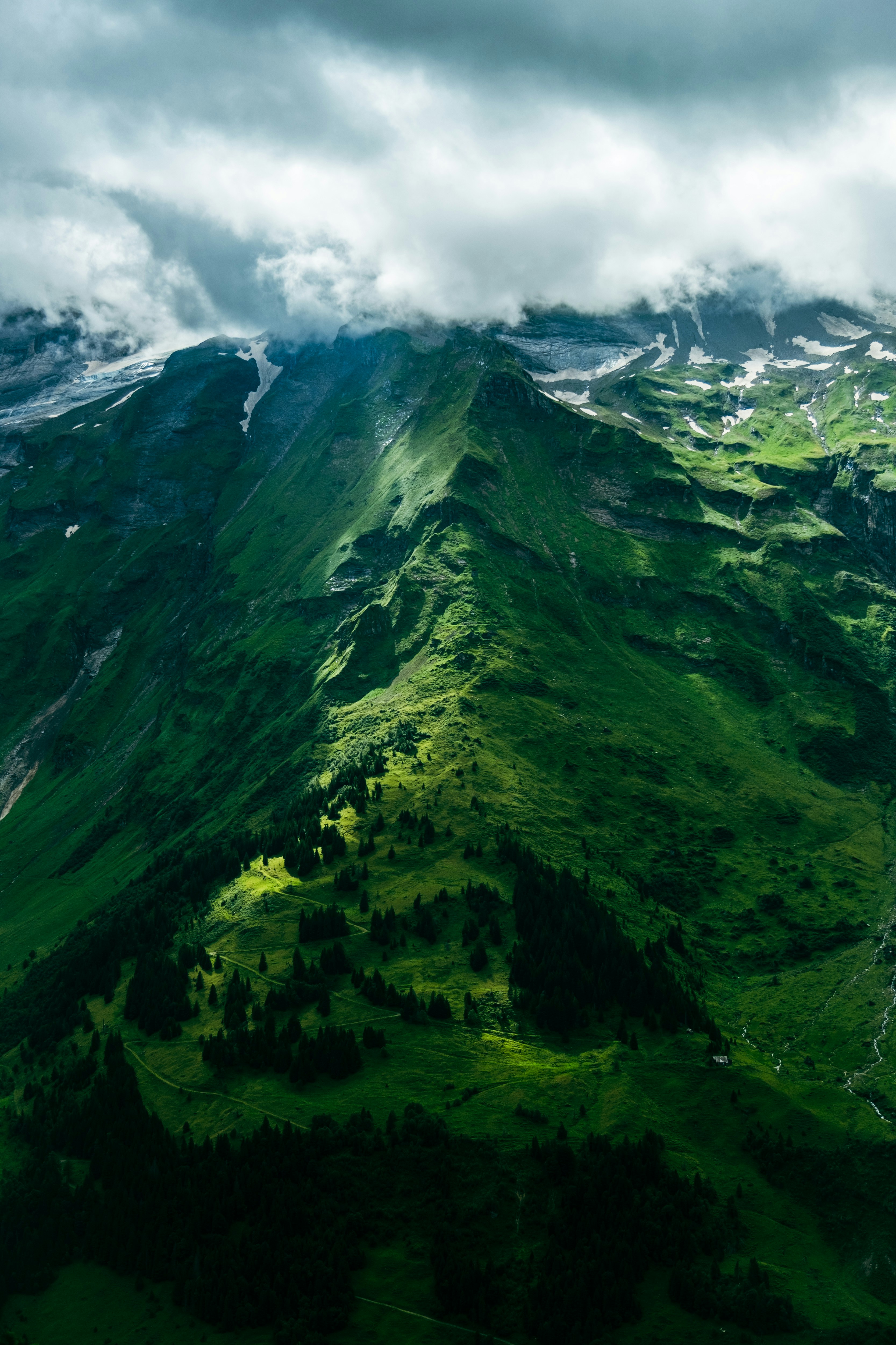 A green mountain range under a cloudy sky photo – Free Vegetation Image ...