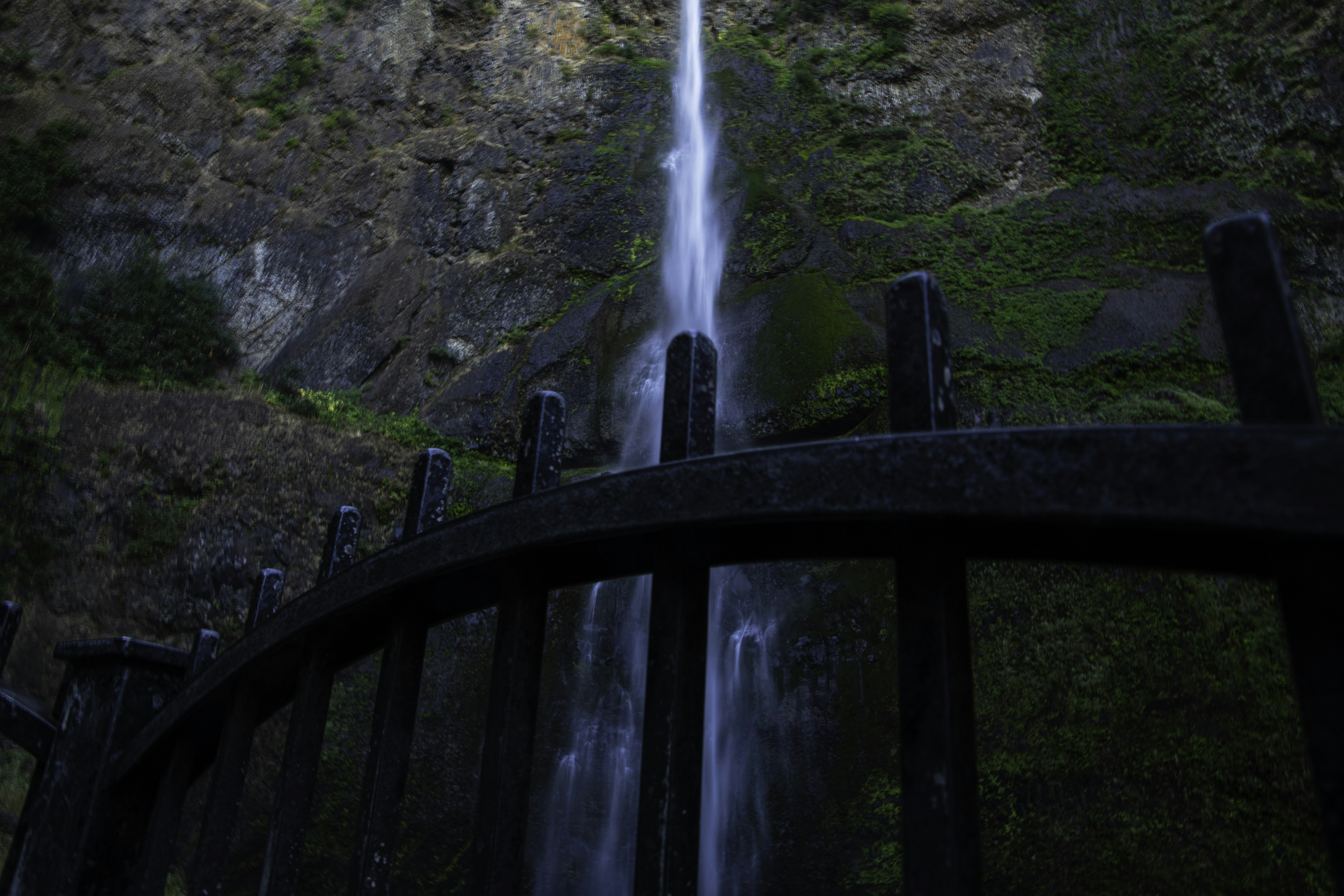 A tall waterfall with a black gate in front of it photo – Free Forest ...