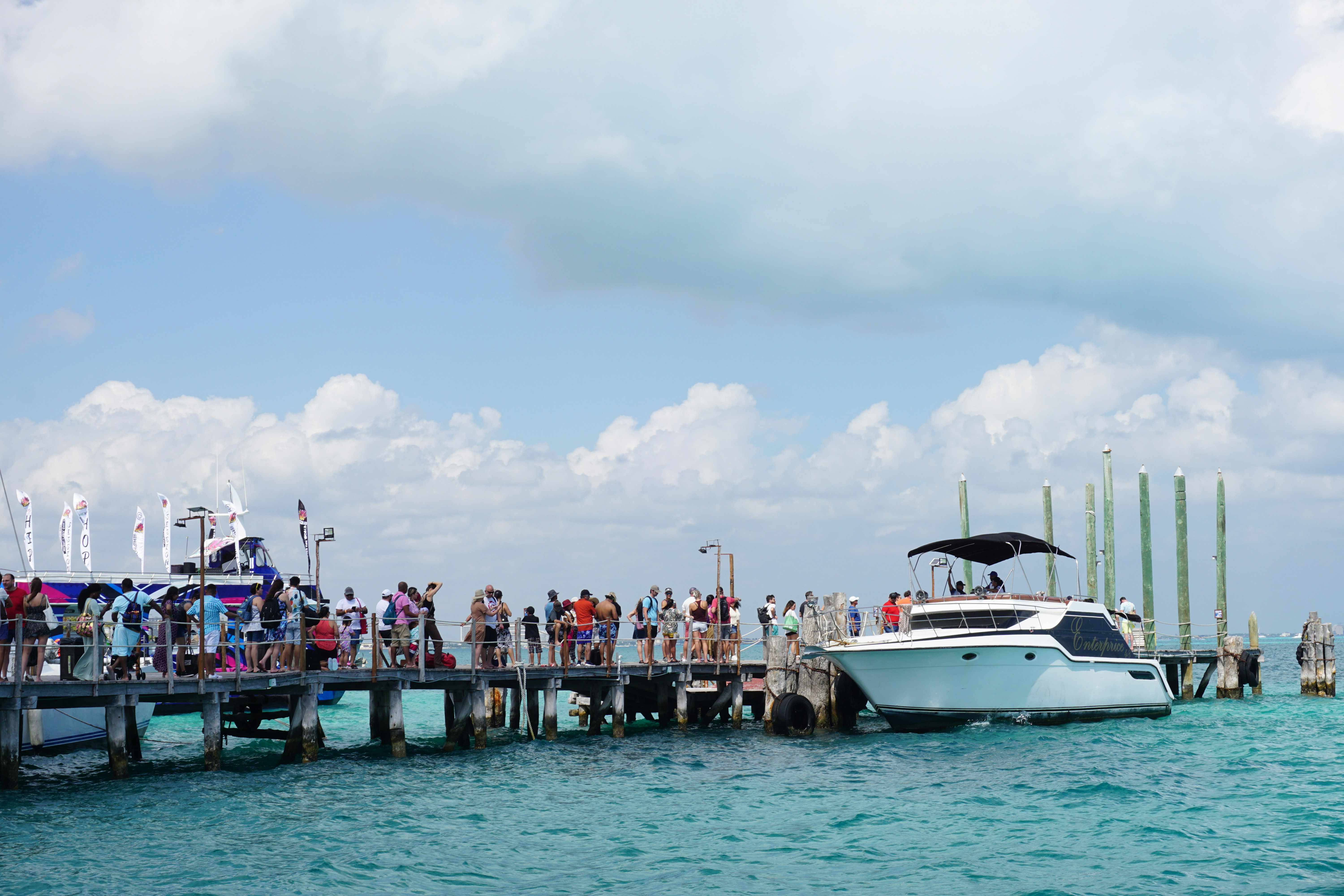Harbor Crowd and a White Motorboat: A Sunlit Turquoise Sea Moment