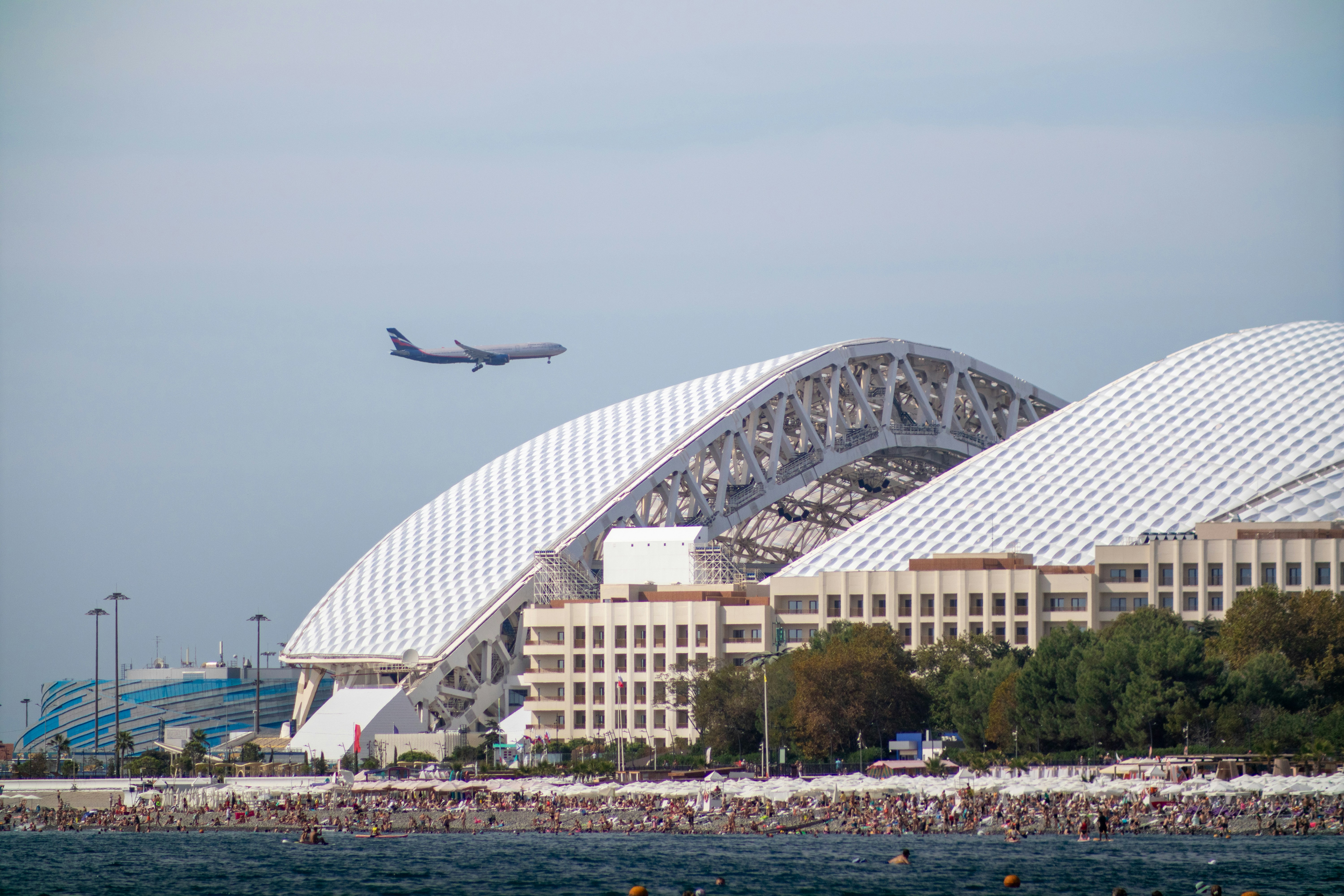 An airplane is flying over a large building