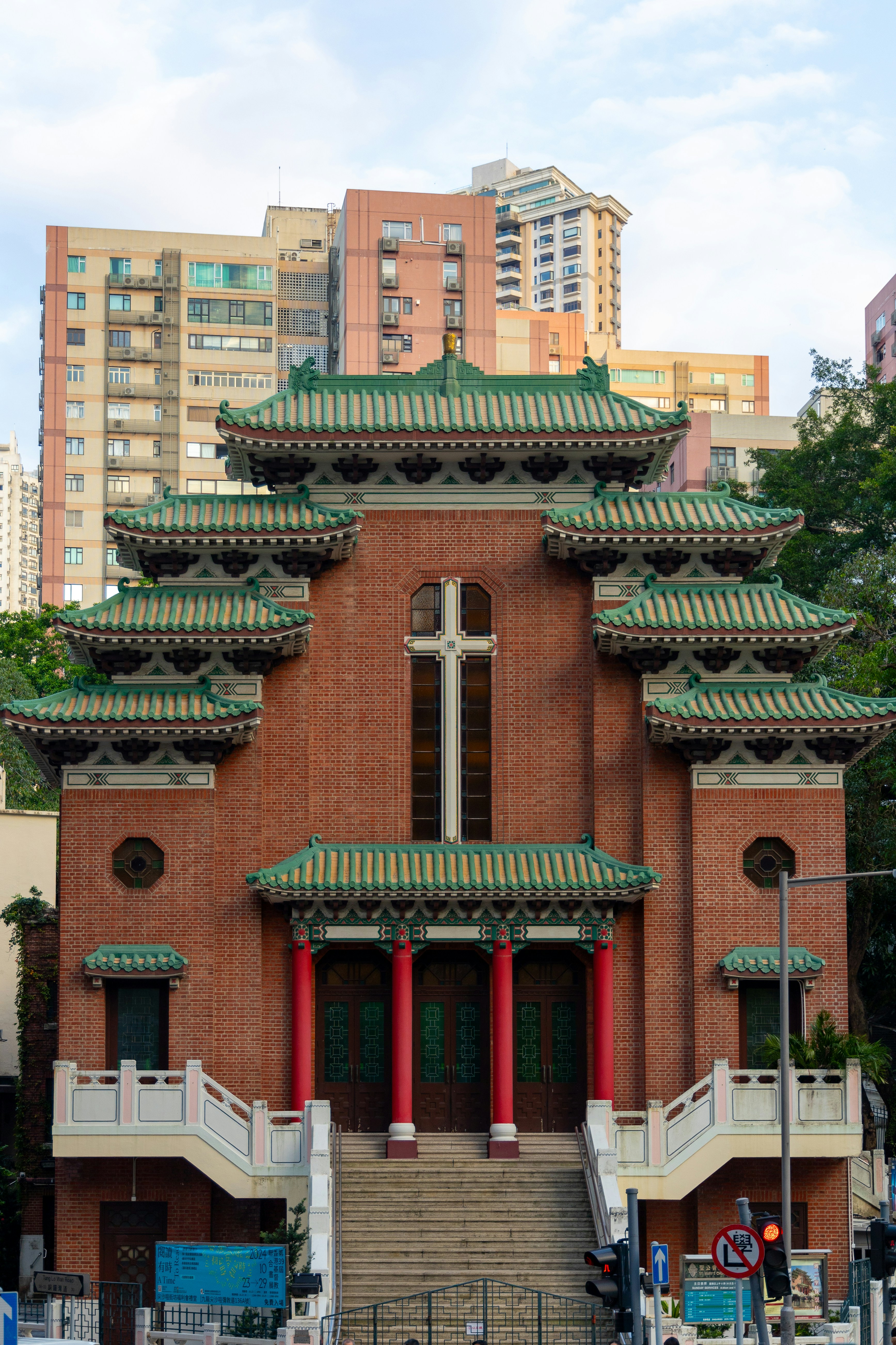 Red Brick Shrine with Green Tiled Roofs Amid Urban Towers
