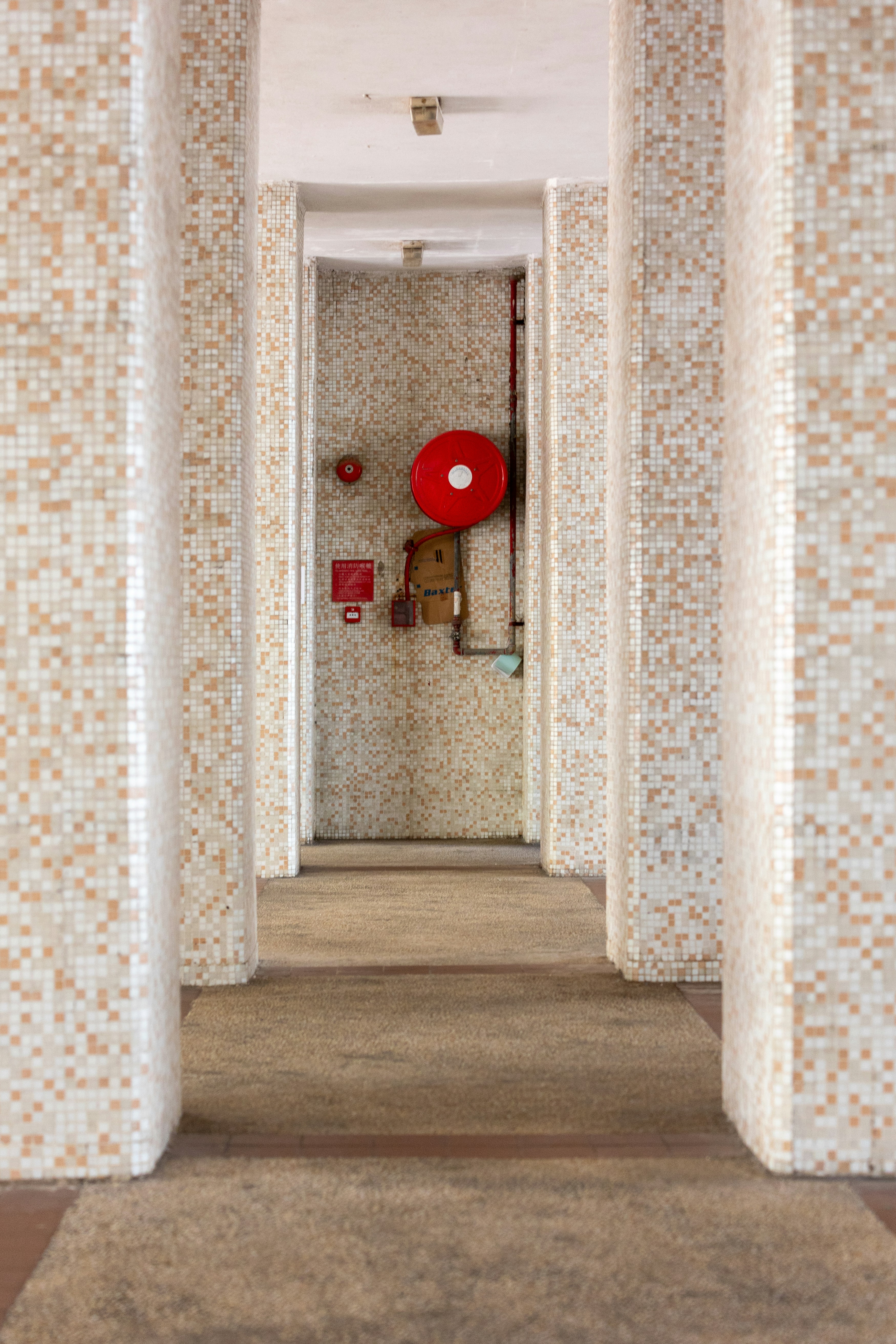 A long hallway with a red fire hydrant on the wall