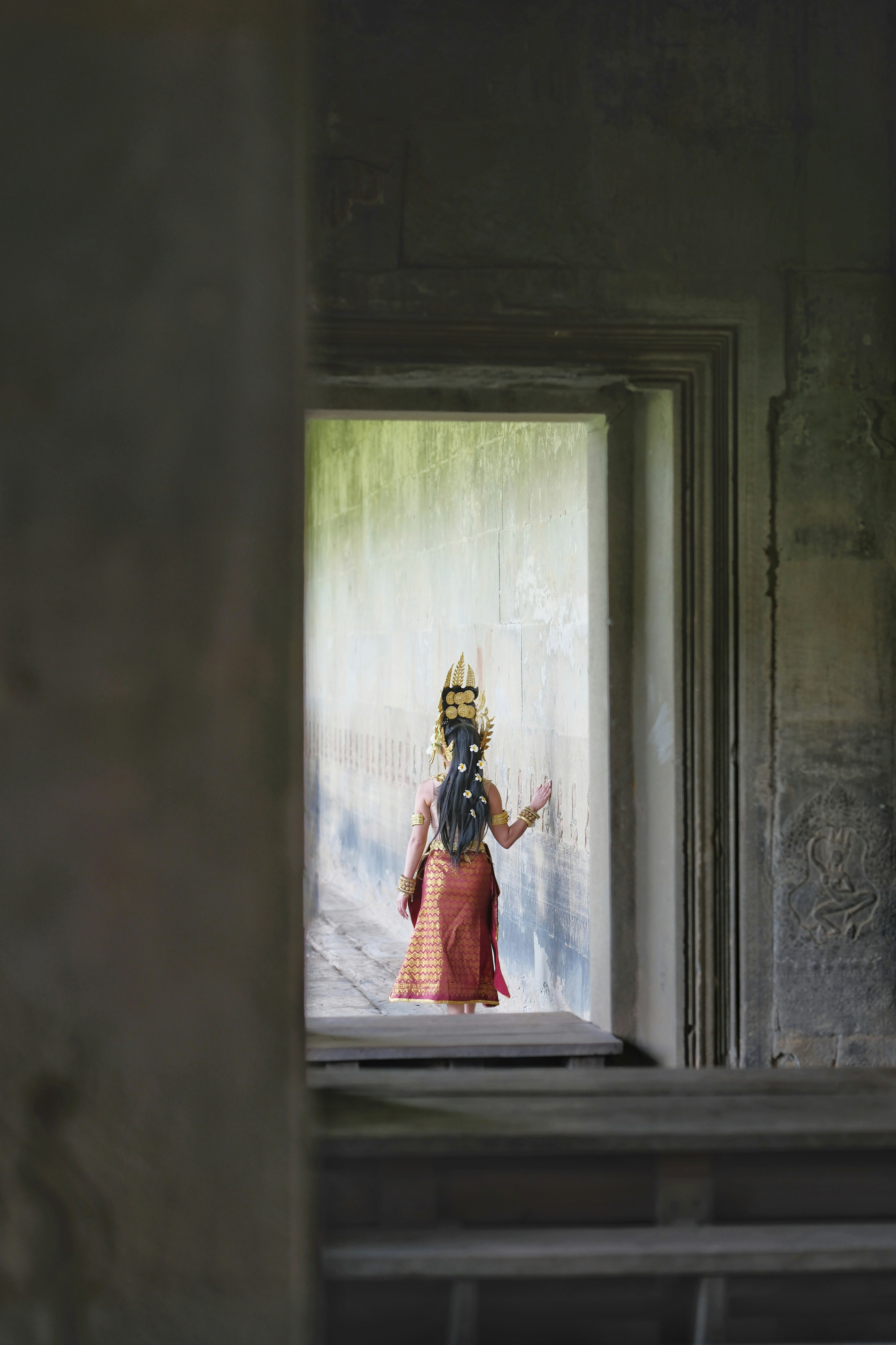 Threshold of Light: A Traditional Dancer Framed by a Temple Corridor