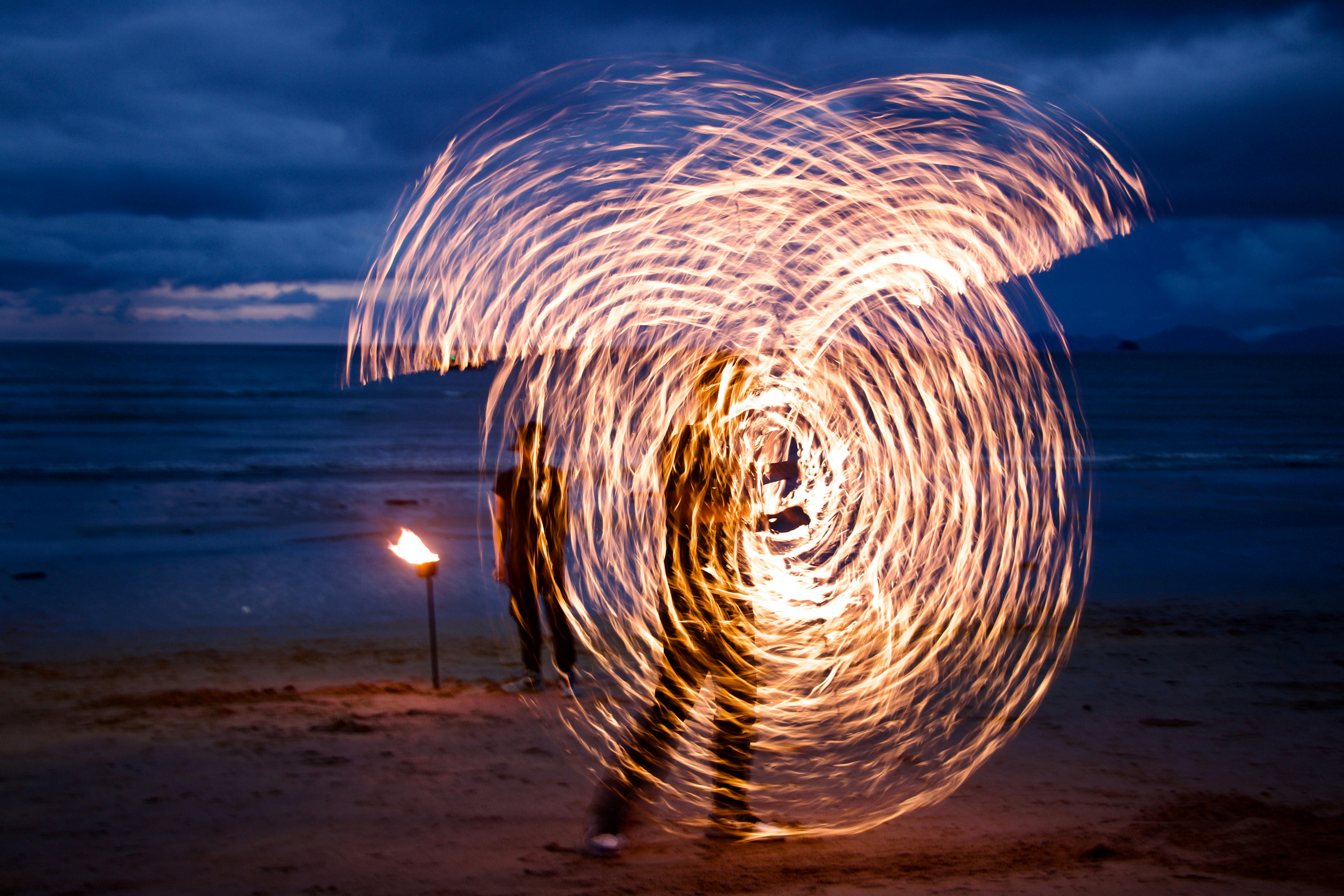 Spiral of Sparks: A Beachfront Ring of Light at Dusk