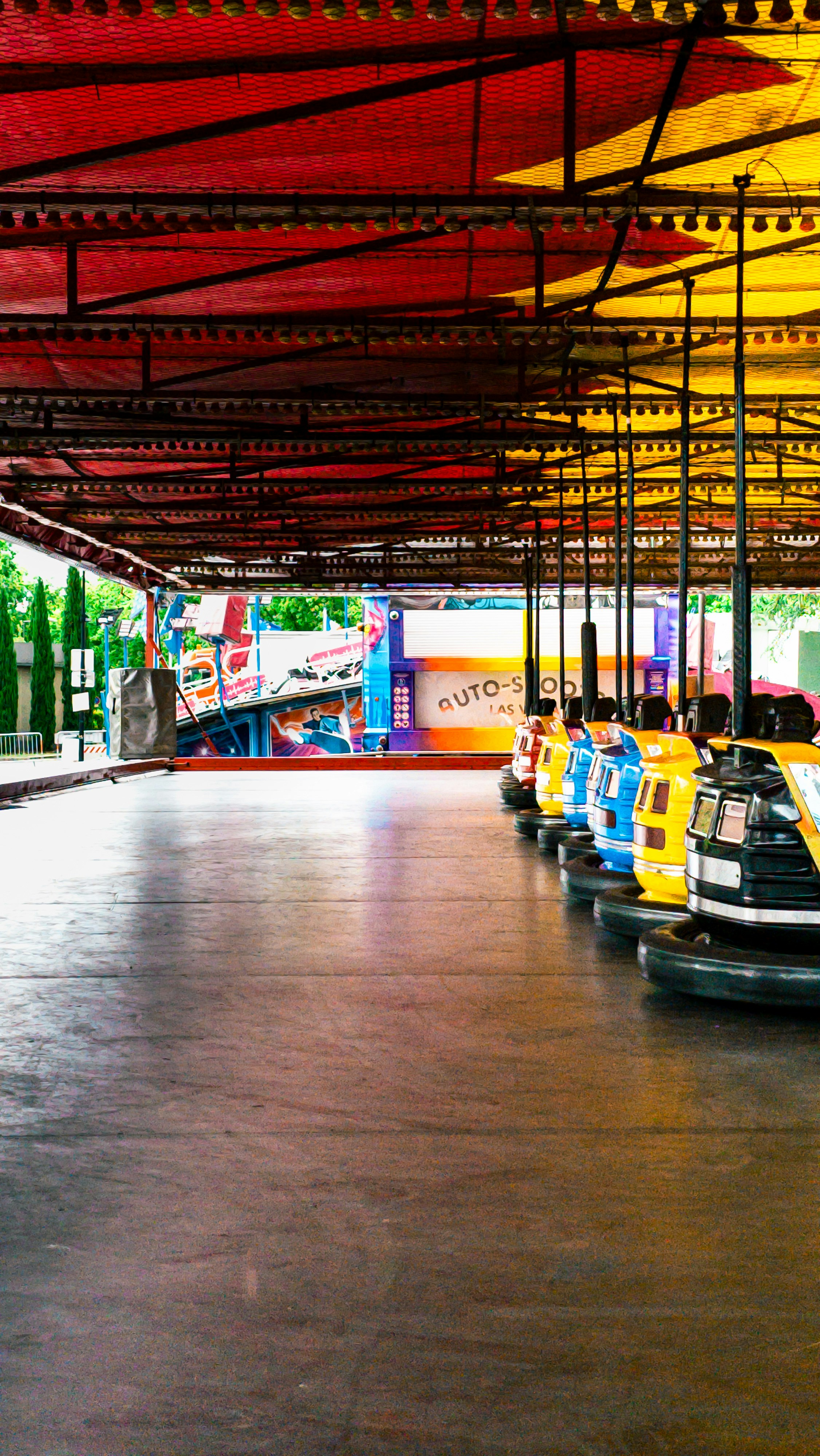 A row of bumper cars parked under a covered area photo – Free Bumper ...